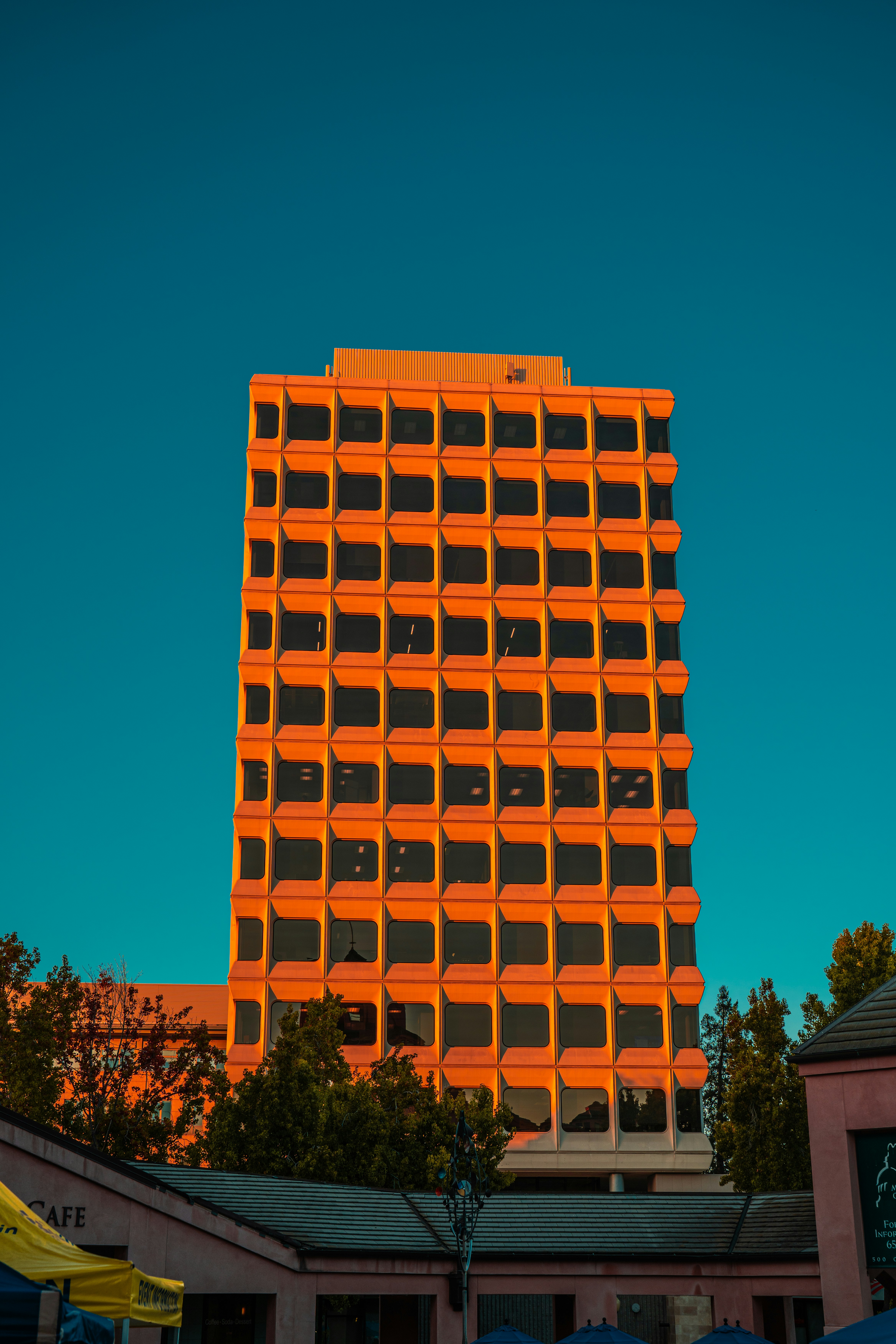 Orange-Fronted Tower: A Sunlit Facade Against a Teal Sky