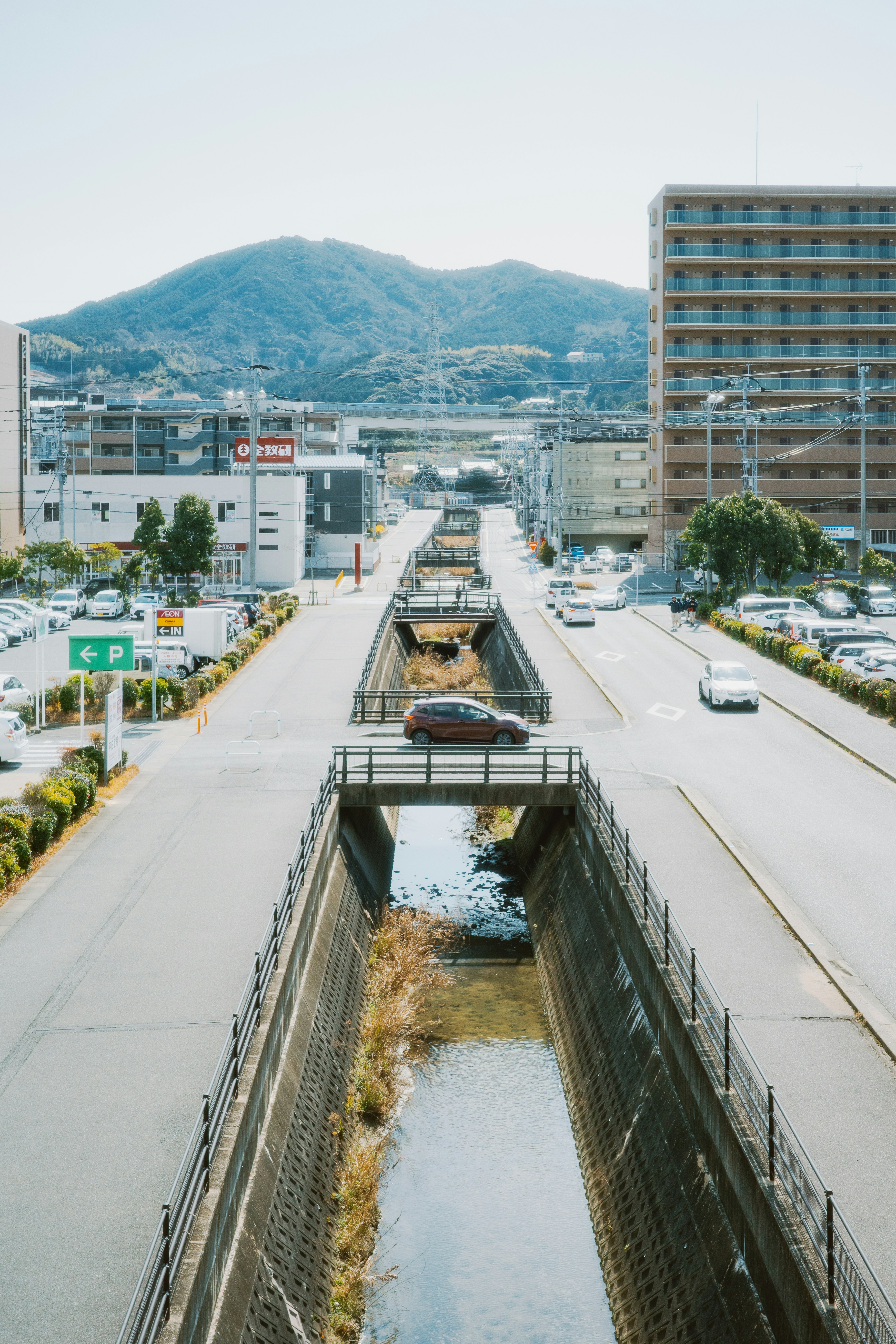 Urban Canal Corridor: A Quiet Car Stack Descends Through the City