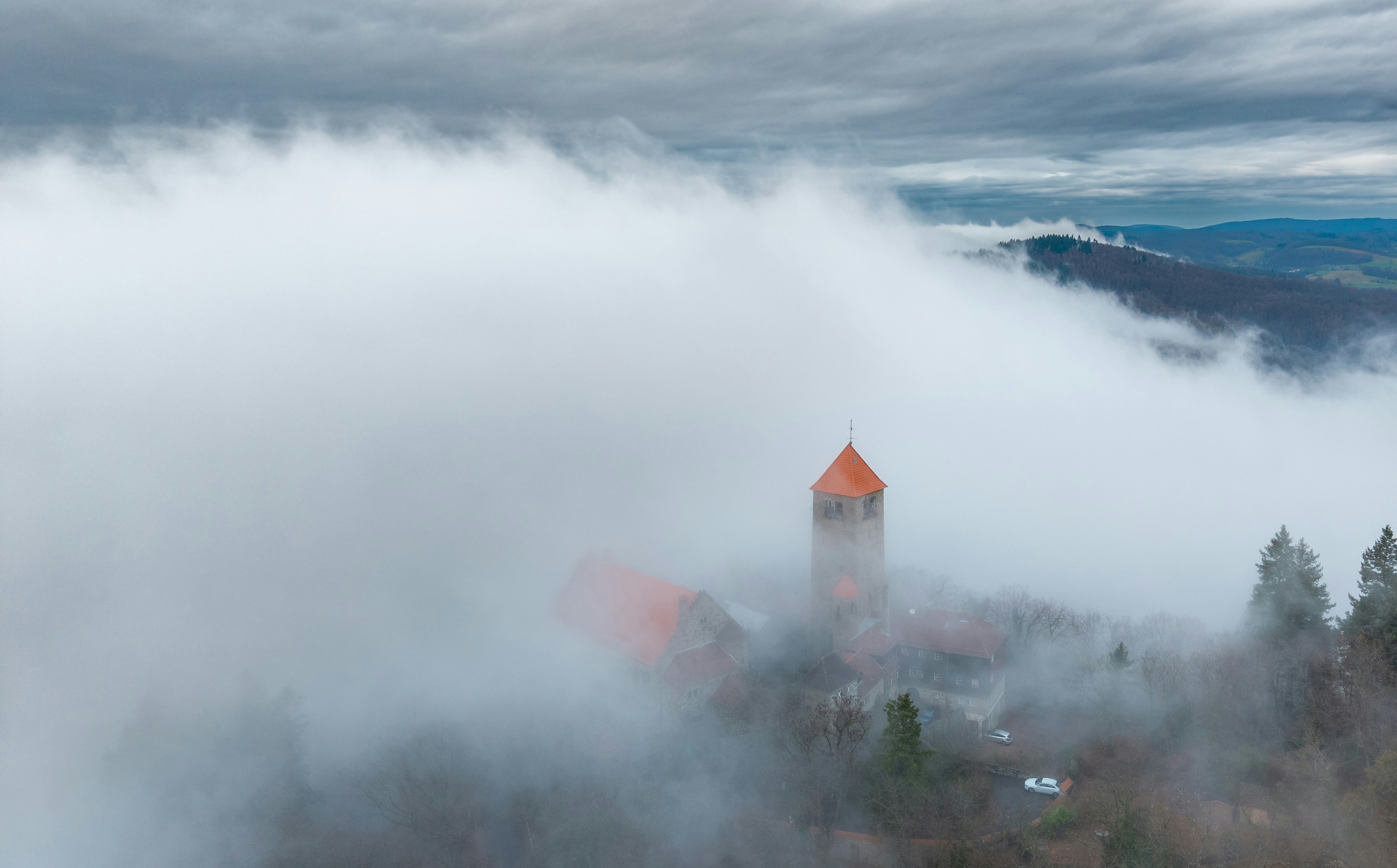 Mist-Shrouded Bell Tower Emerges Through Low-Cloud Veil