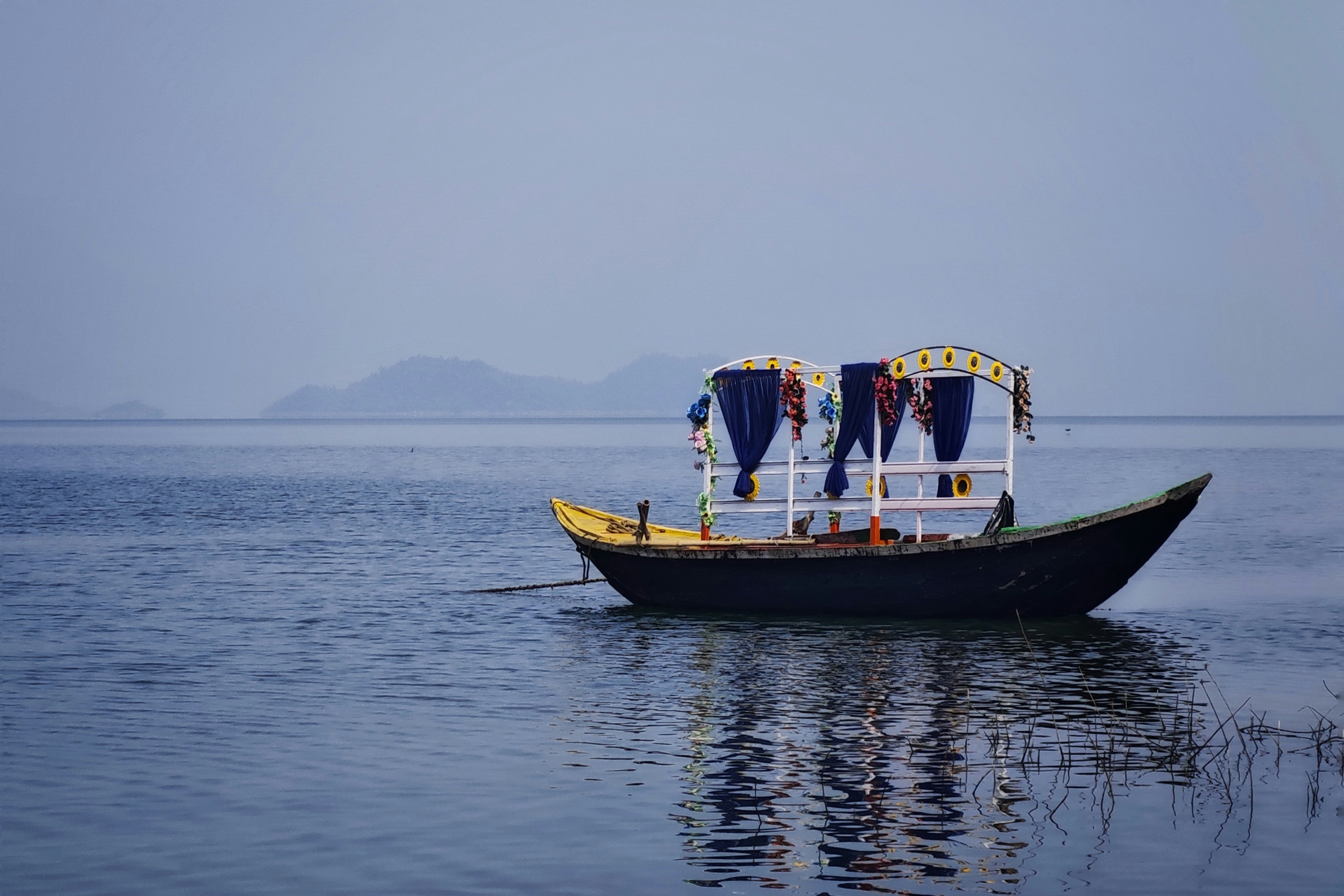 Floating Serene: A lone boat under a soft harbor haze