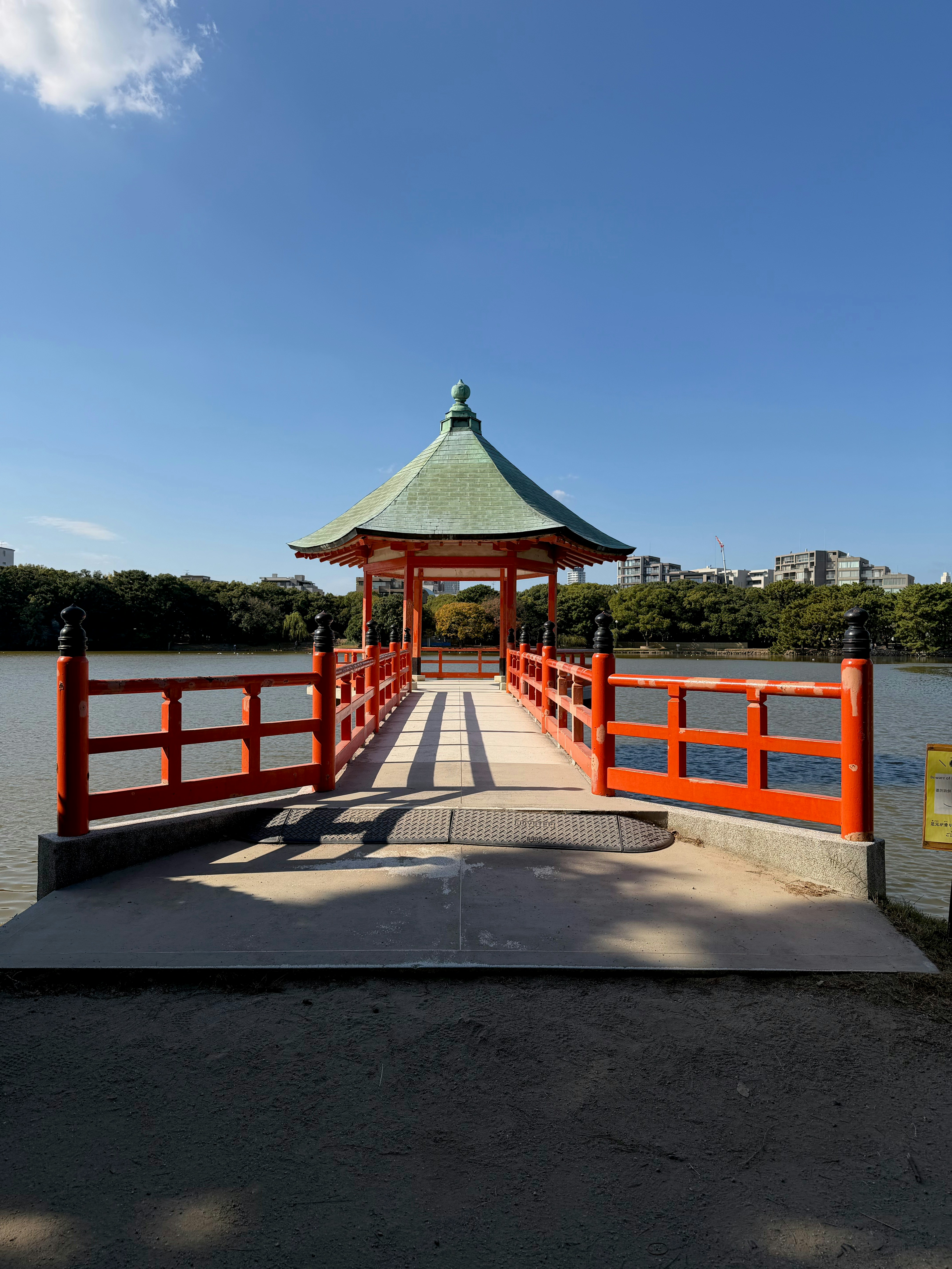 Red Pavilion Pier Extends into a Calm Lake Under a Clear Sky