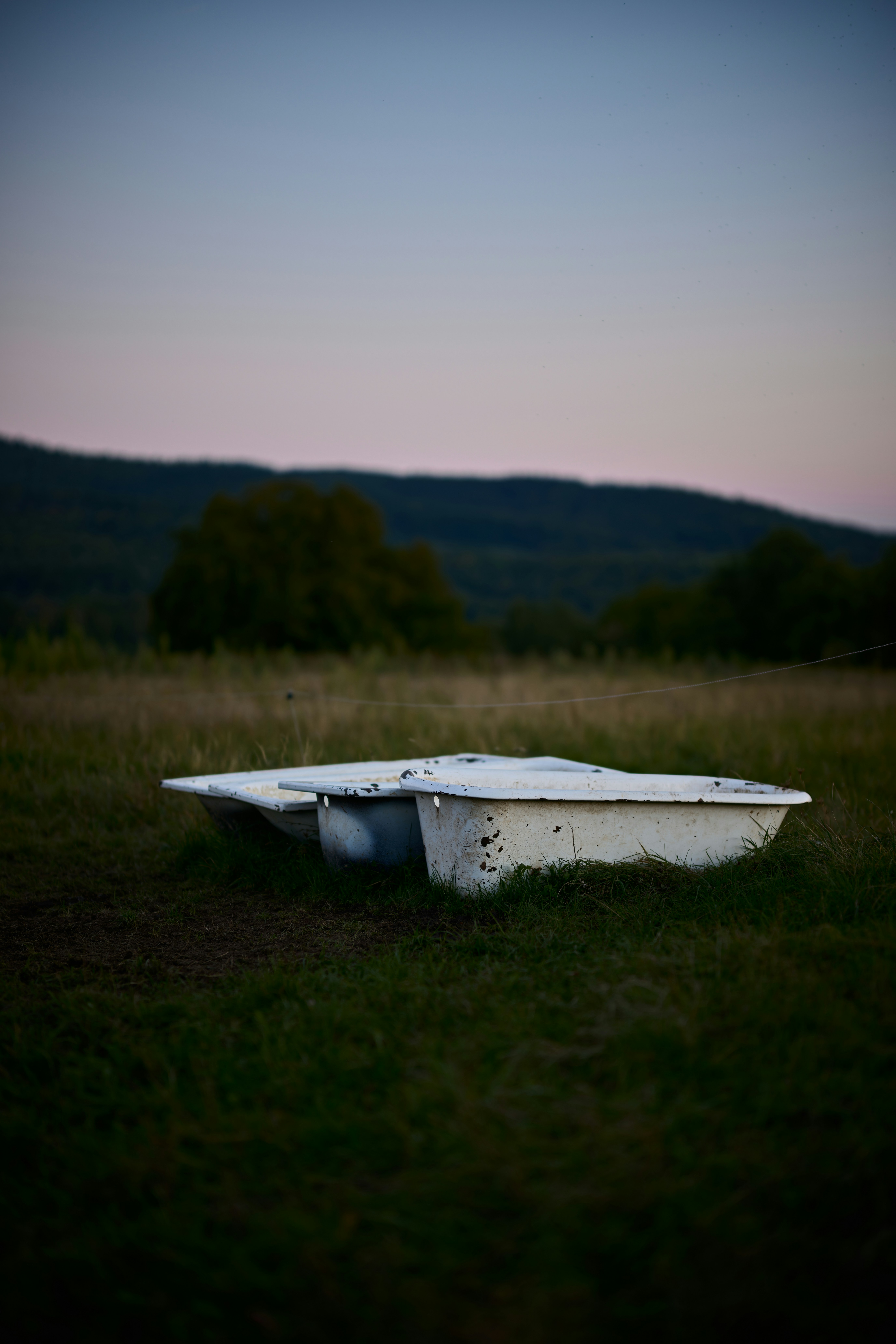Floating White Boats Rest at Dusk in a Quiet Field