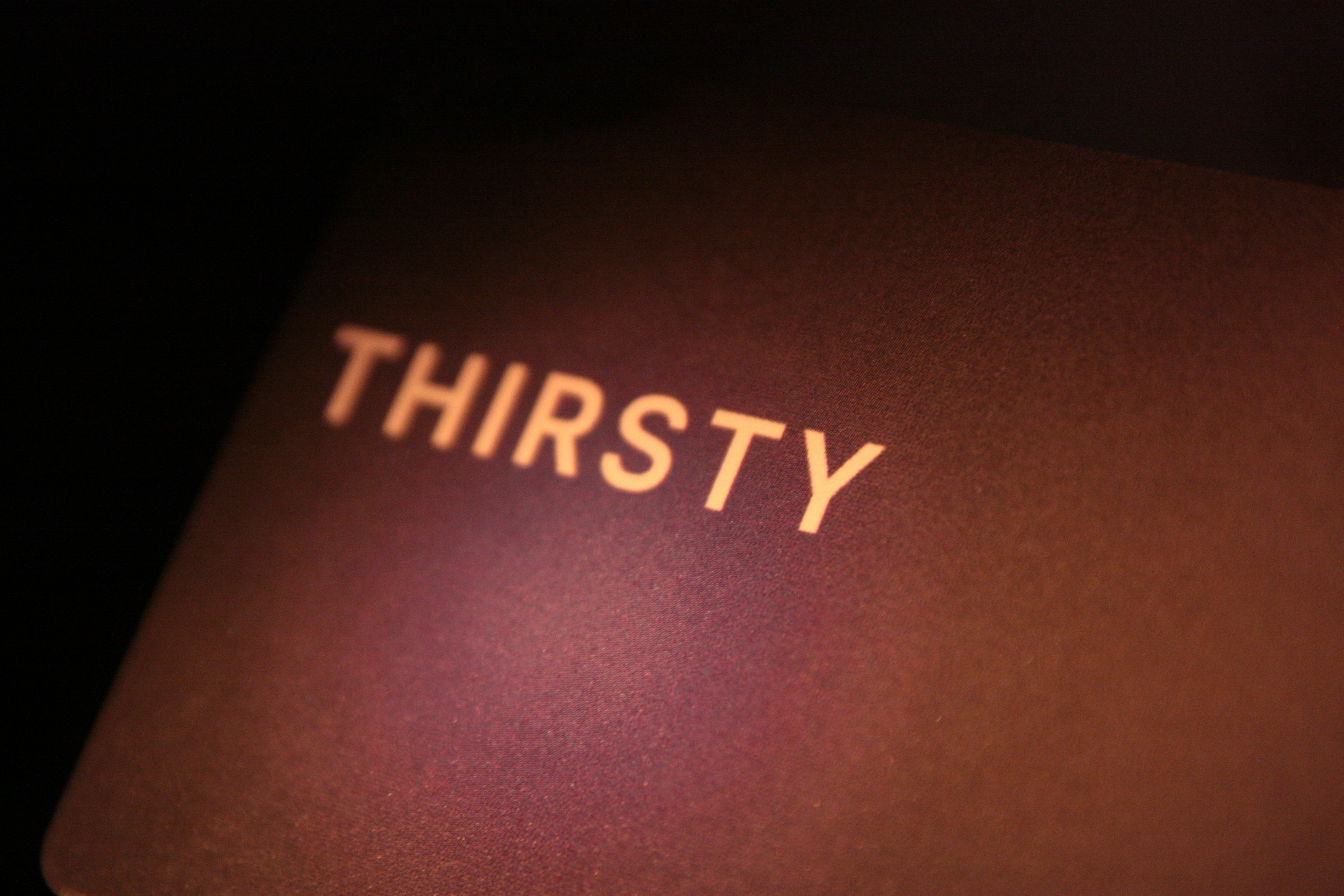 Midnight Glimpse: The THIRSTY Sign in Soft, Warm Glow