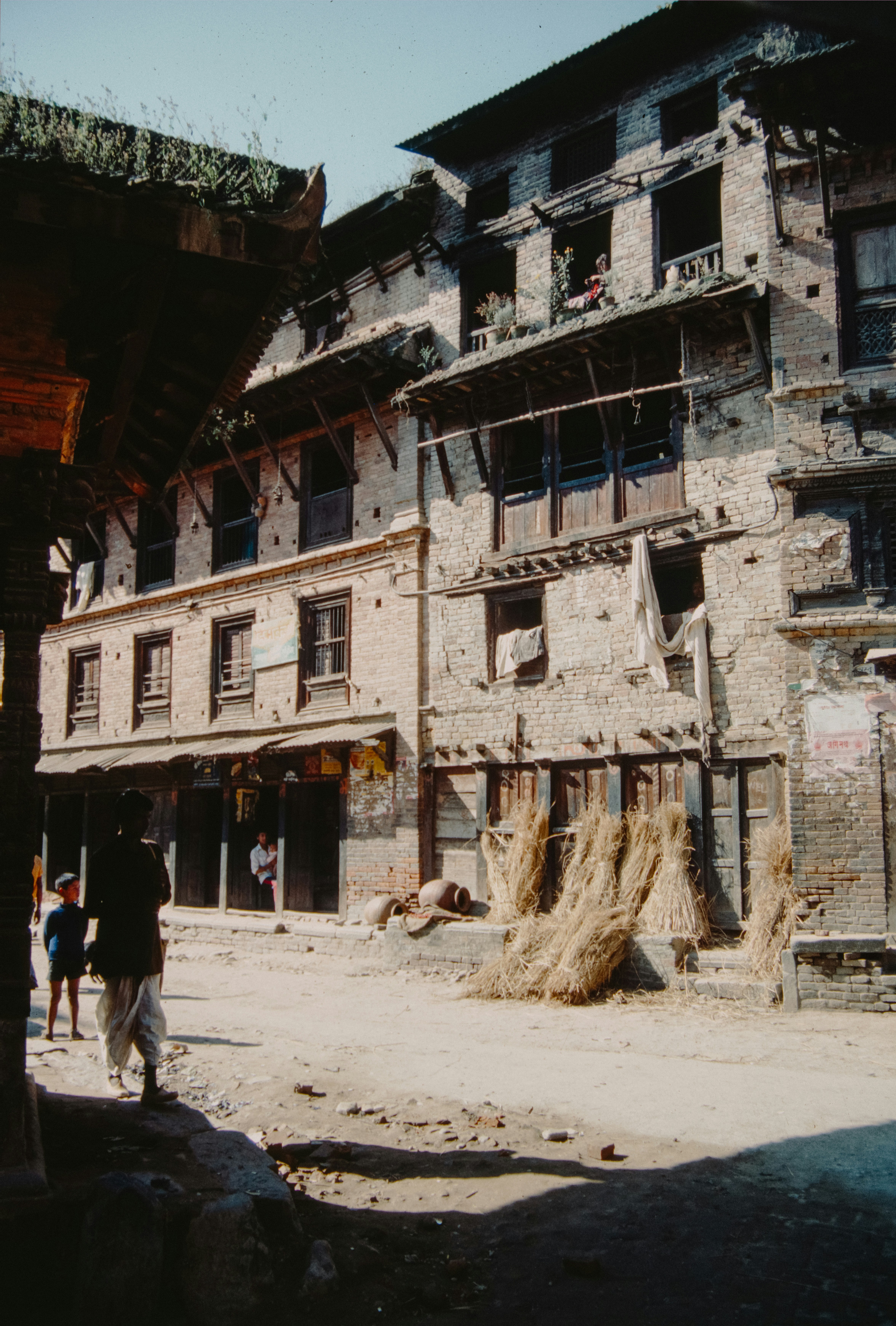 Sunlit Facade and Haystack Alley in a Dusty Bazaar