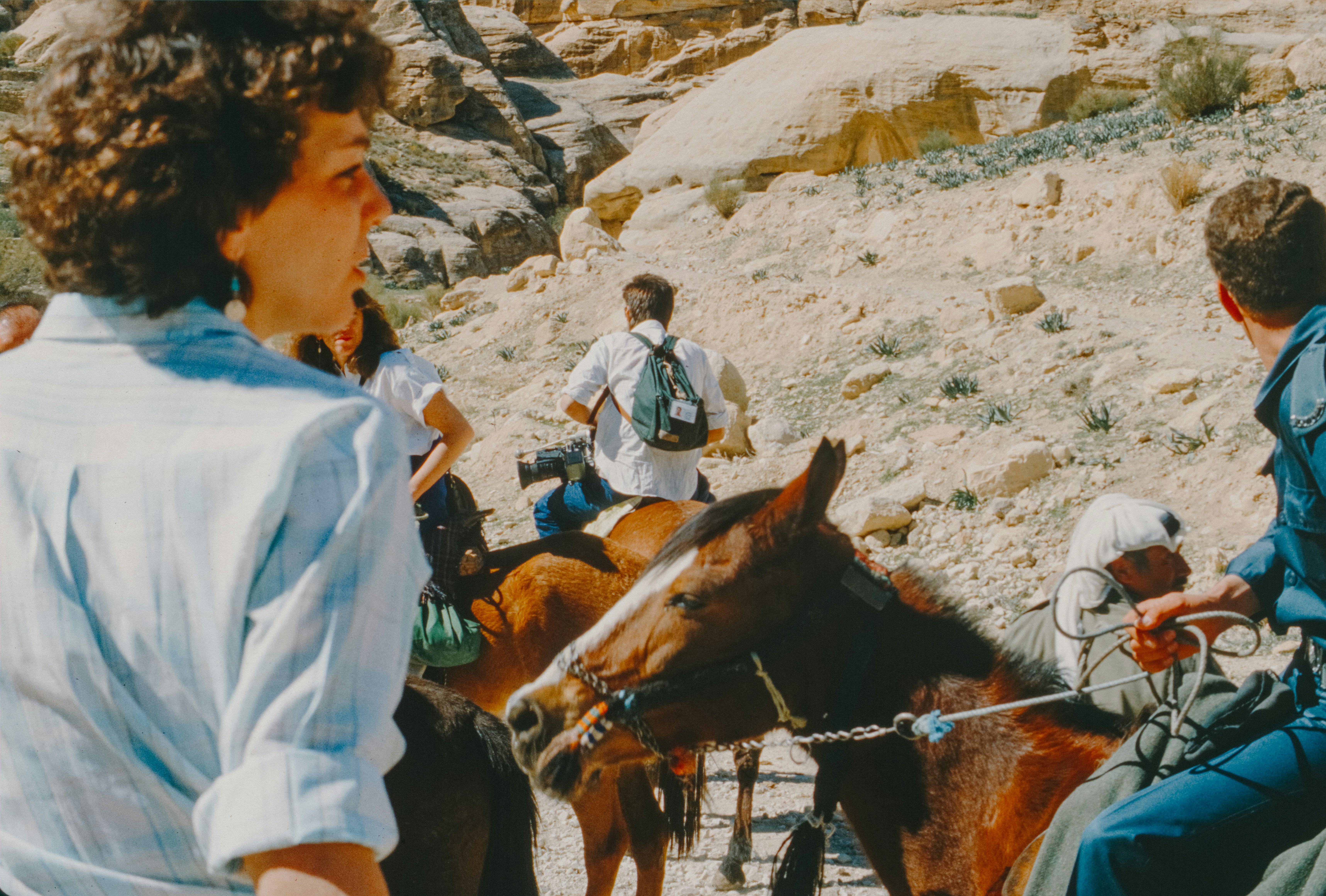 Encounter in the Dust: Riders and Horses Amid a Rocky Outcrop