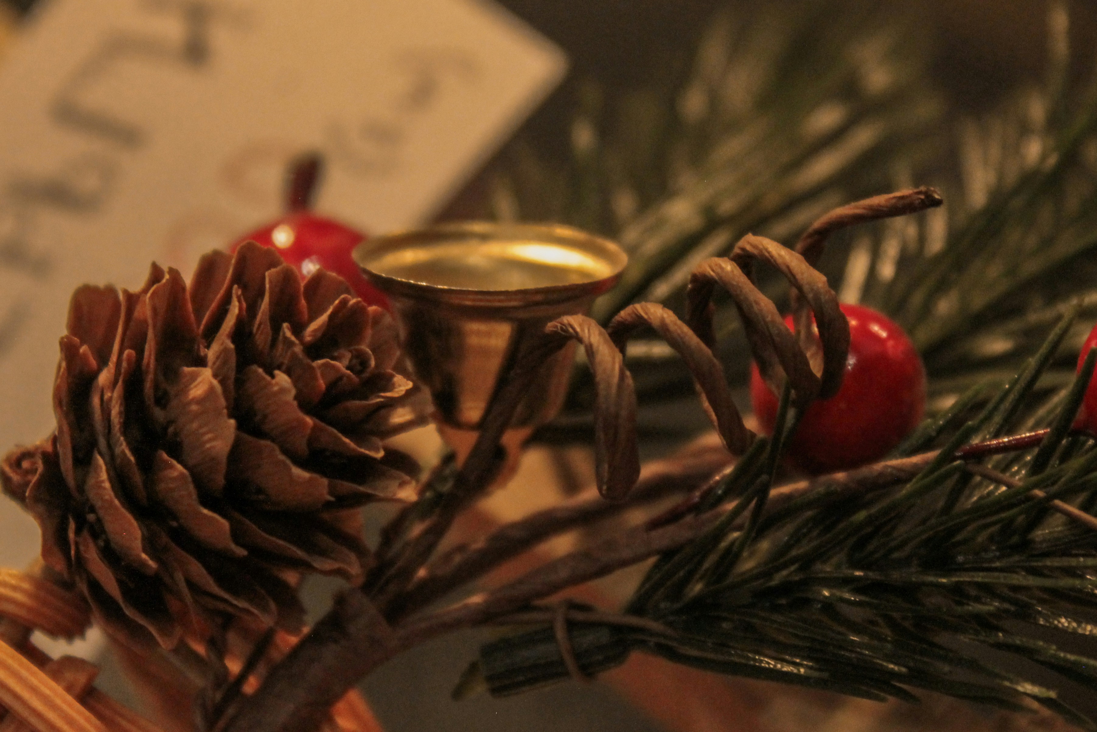 A pinecone and candle vignette tucked among holiday greens