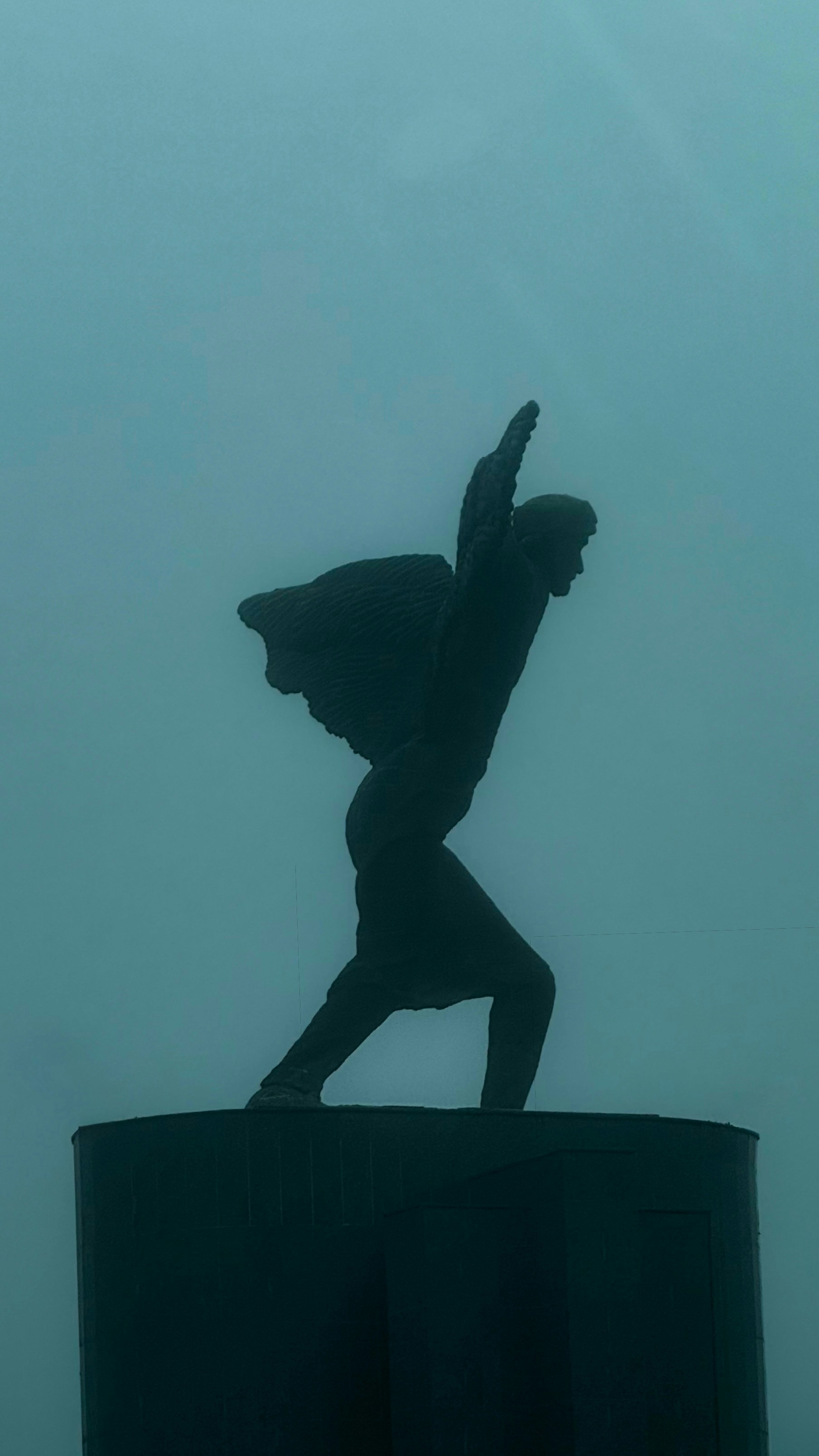 A statue of a winged figure carrying a burden photo – Free Sky ...