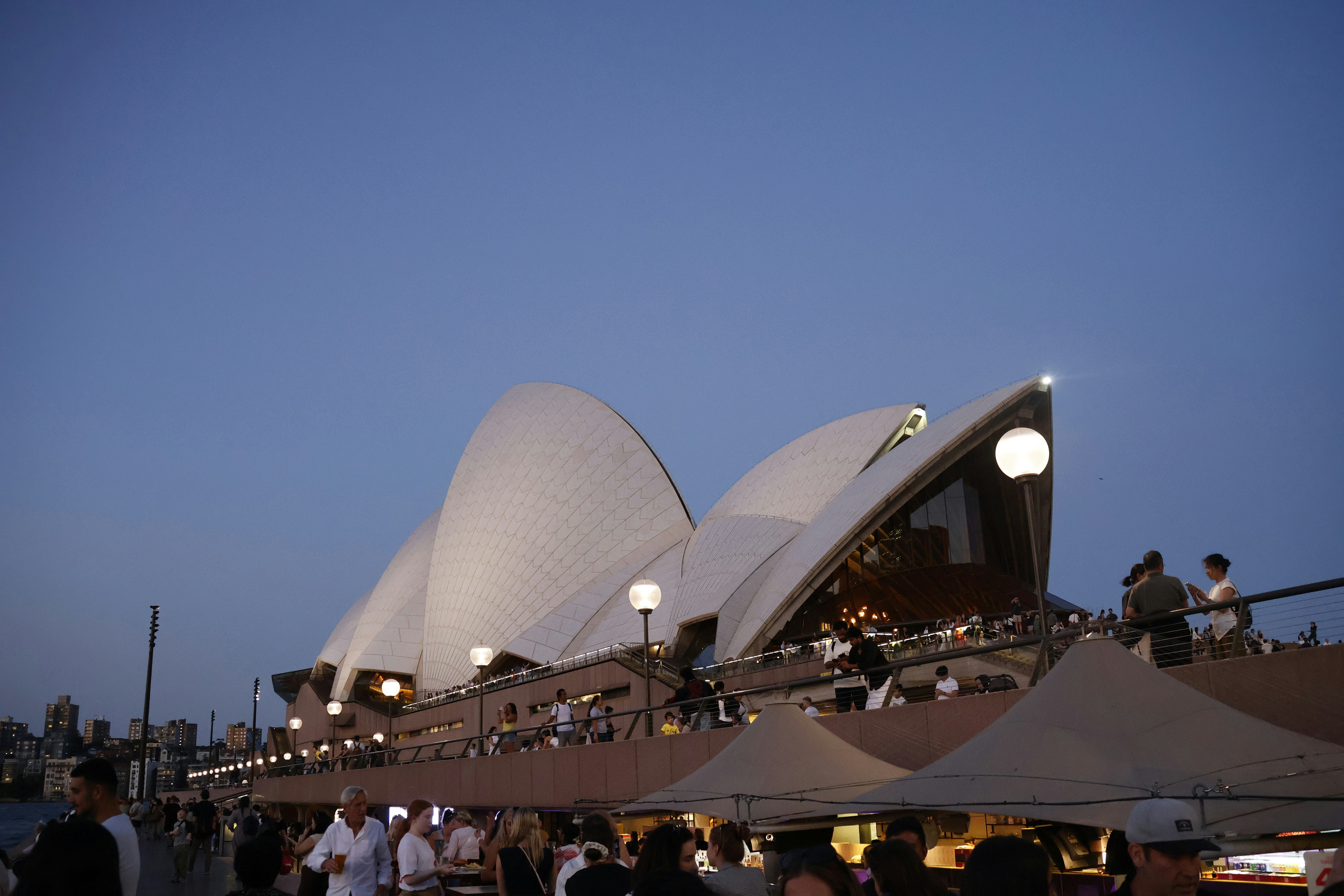Evening at the Opera Deck: Sail-like Roofs Framing a Lively Waterfront