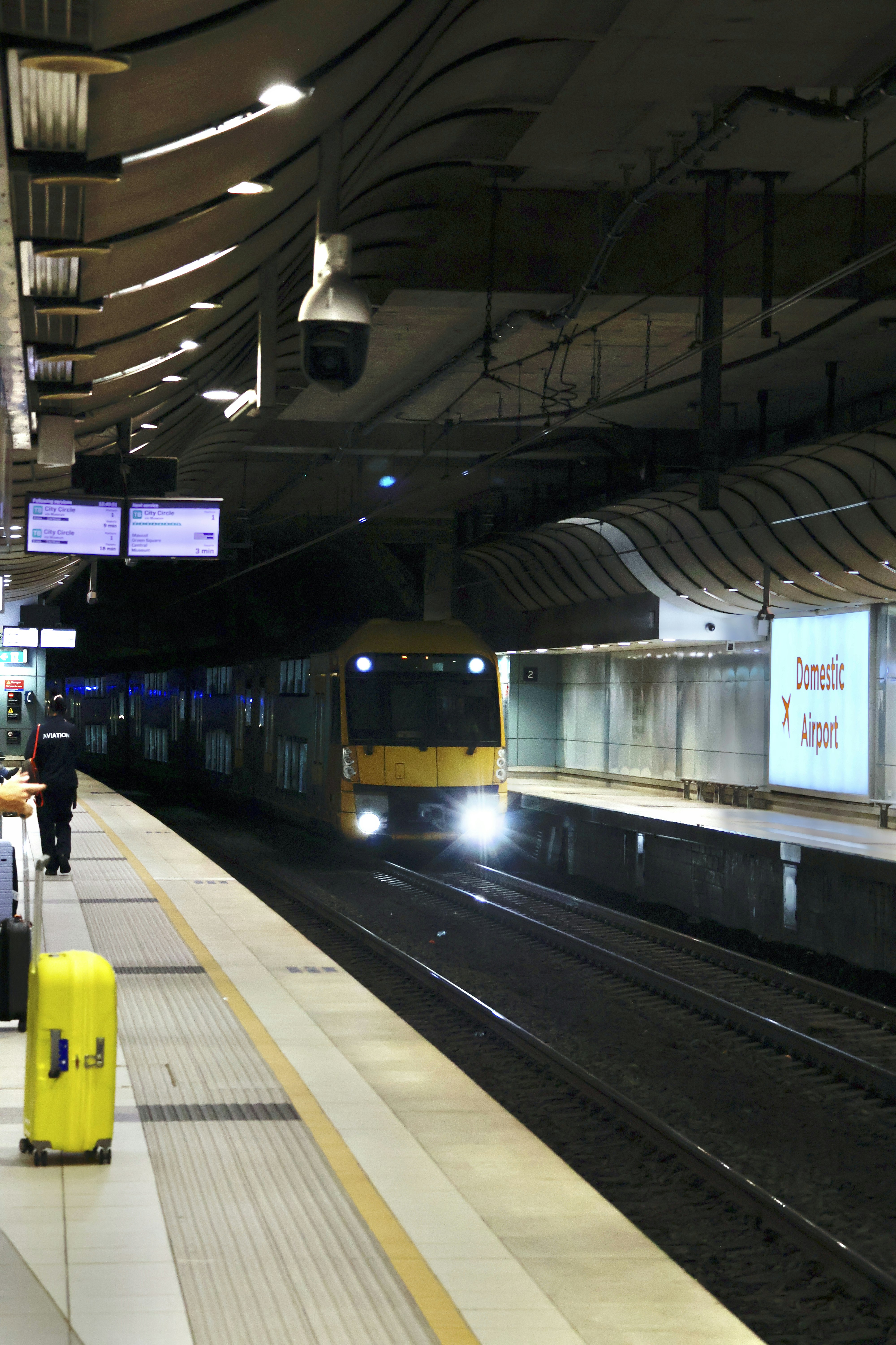 Yellow Train Approaches at a Dimly Lit Underground Station