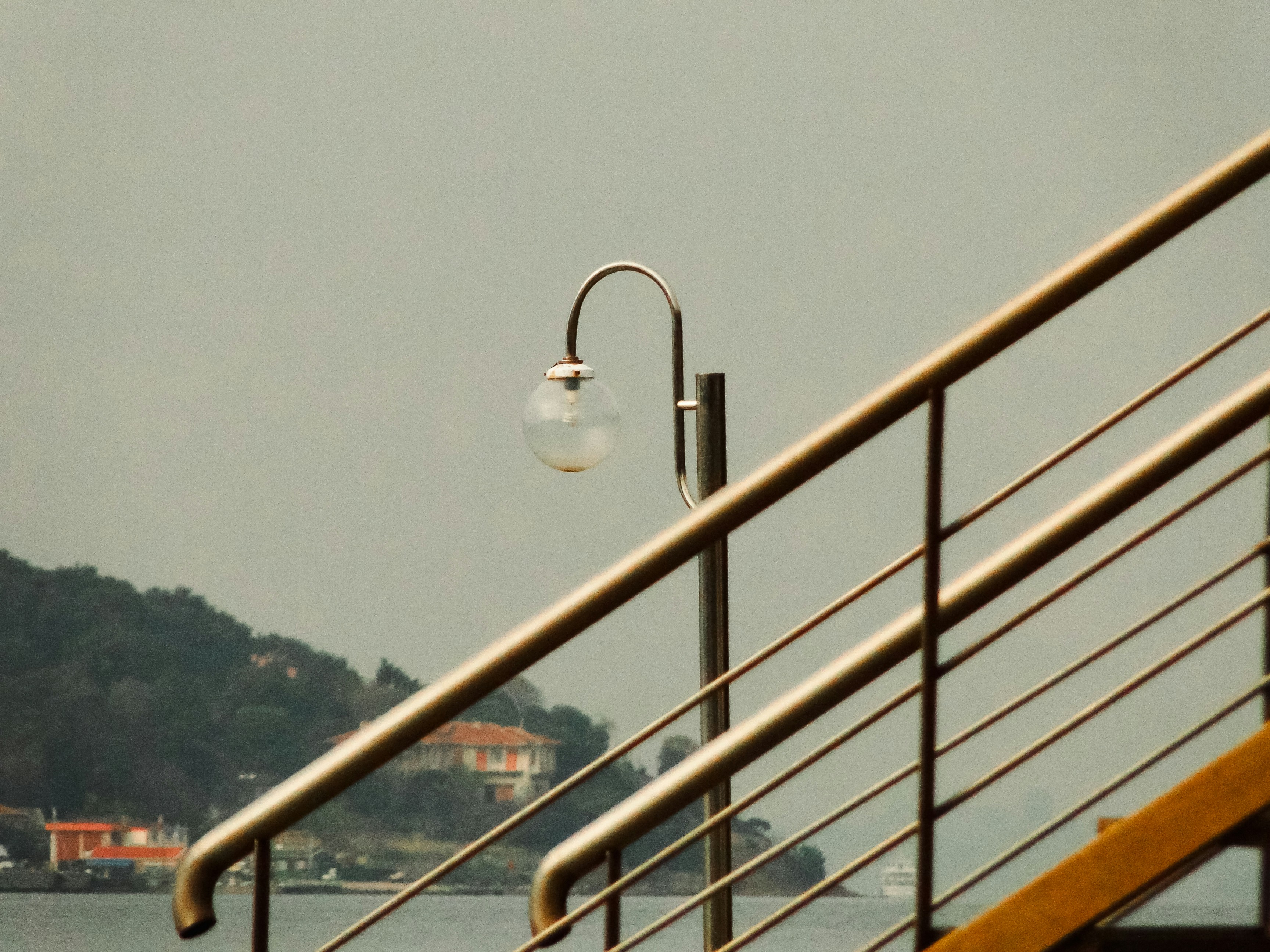 Metal railing and lamp post by the water.