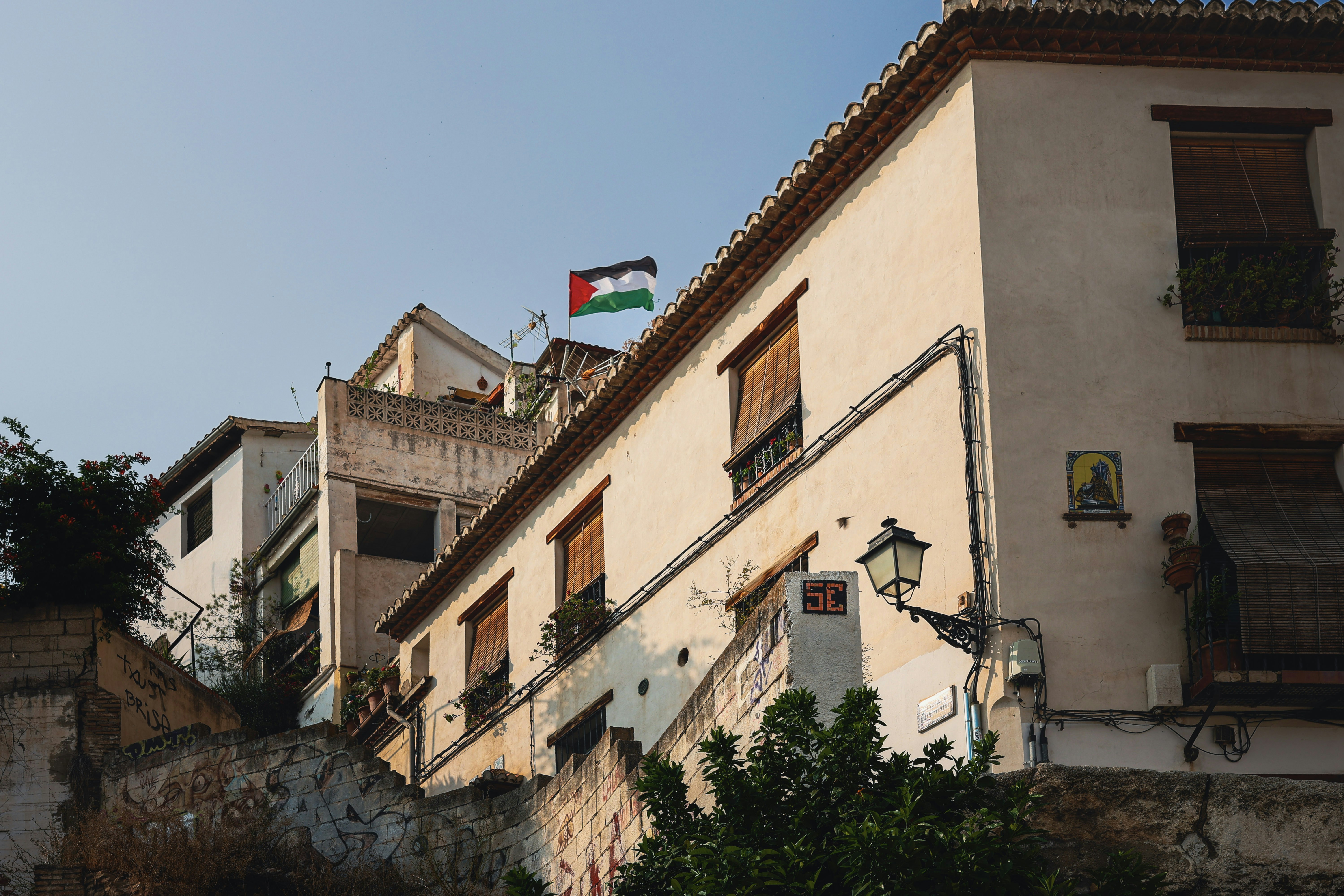Flag Above the Quiet Village: A Sunlit Adobe Speckled with Windows