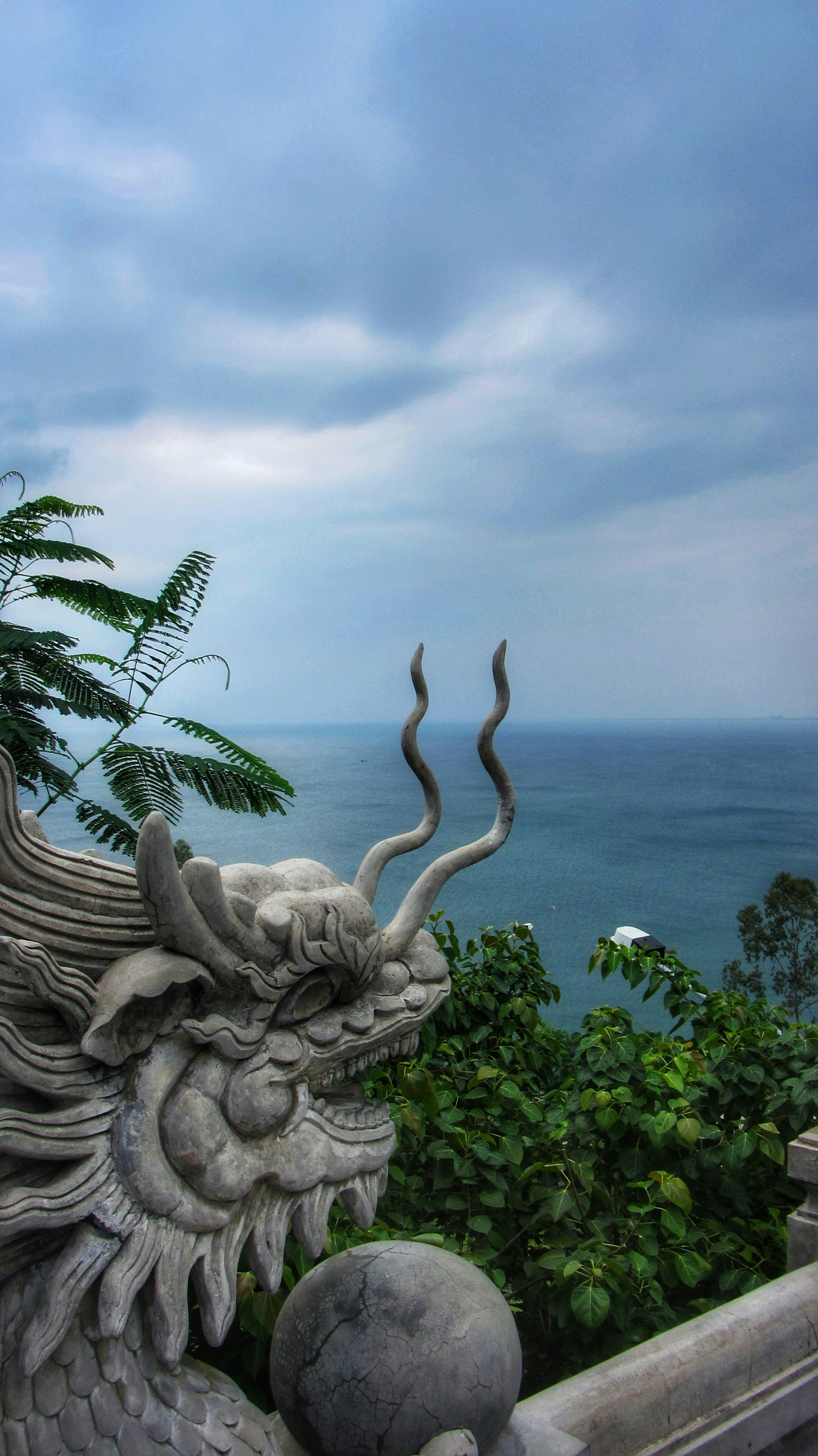 A majestic stone dragon statue stands guard over the vast blue horizon at the Lady Buddha complex on Son Tra Peninsula, Da Nang.