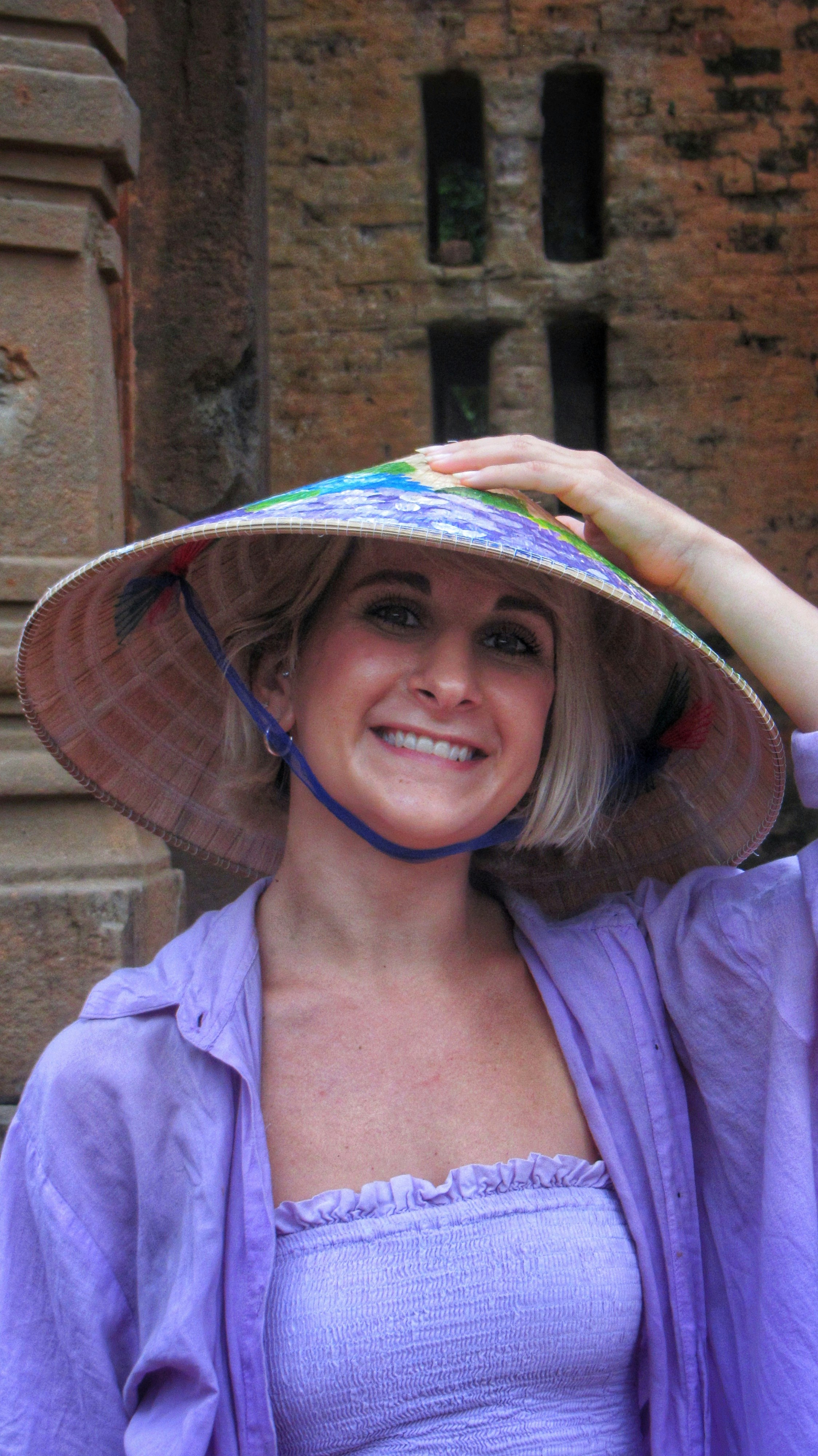 Sunlit Smile Under a Wide Brim: Portrait in Lavender and Stone