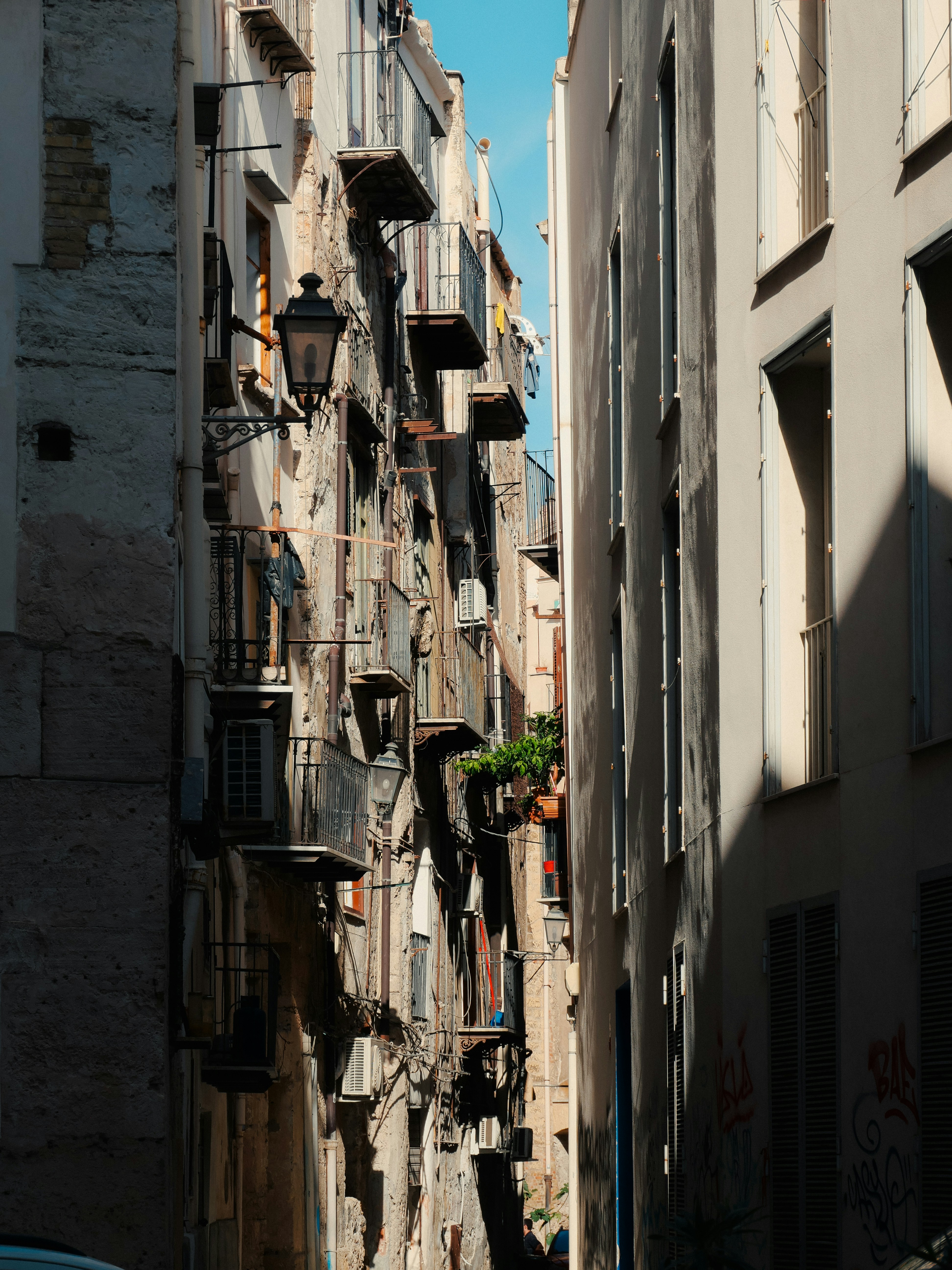 Narrow Mediterranean Alley: Light, Shadow, and Balconies