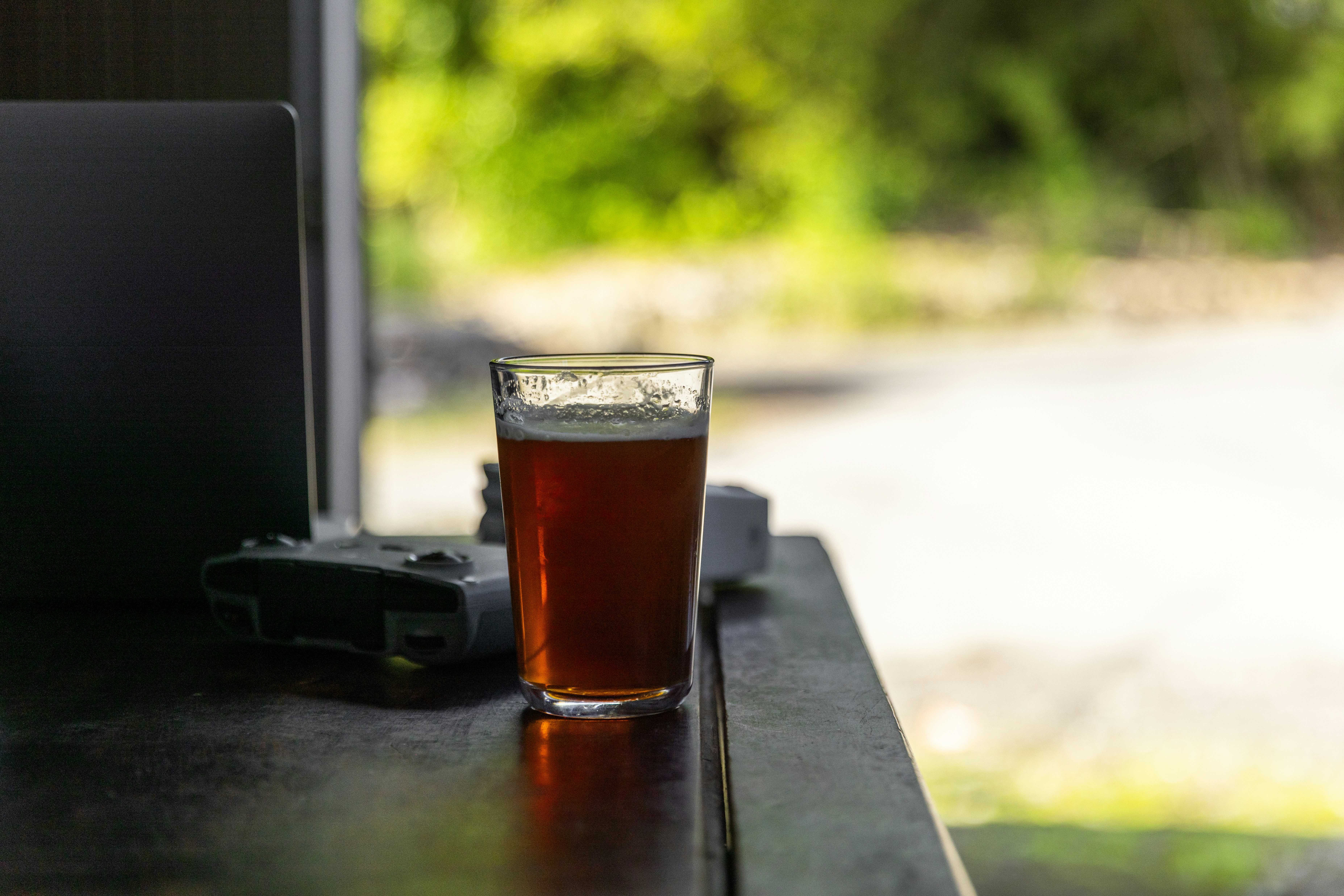 Amber Glass on a Quiet Table: A Moment of Stillness in Sunlit Outdoors