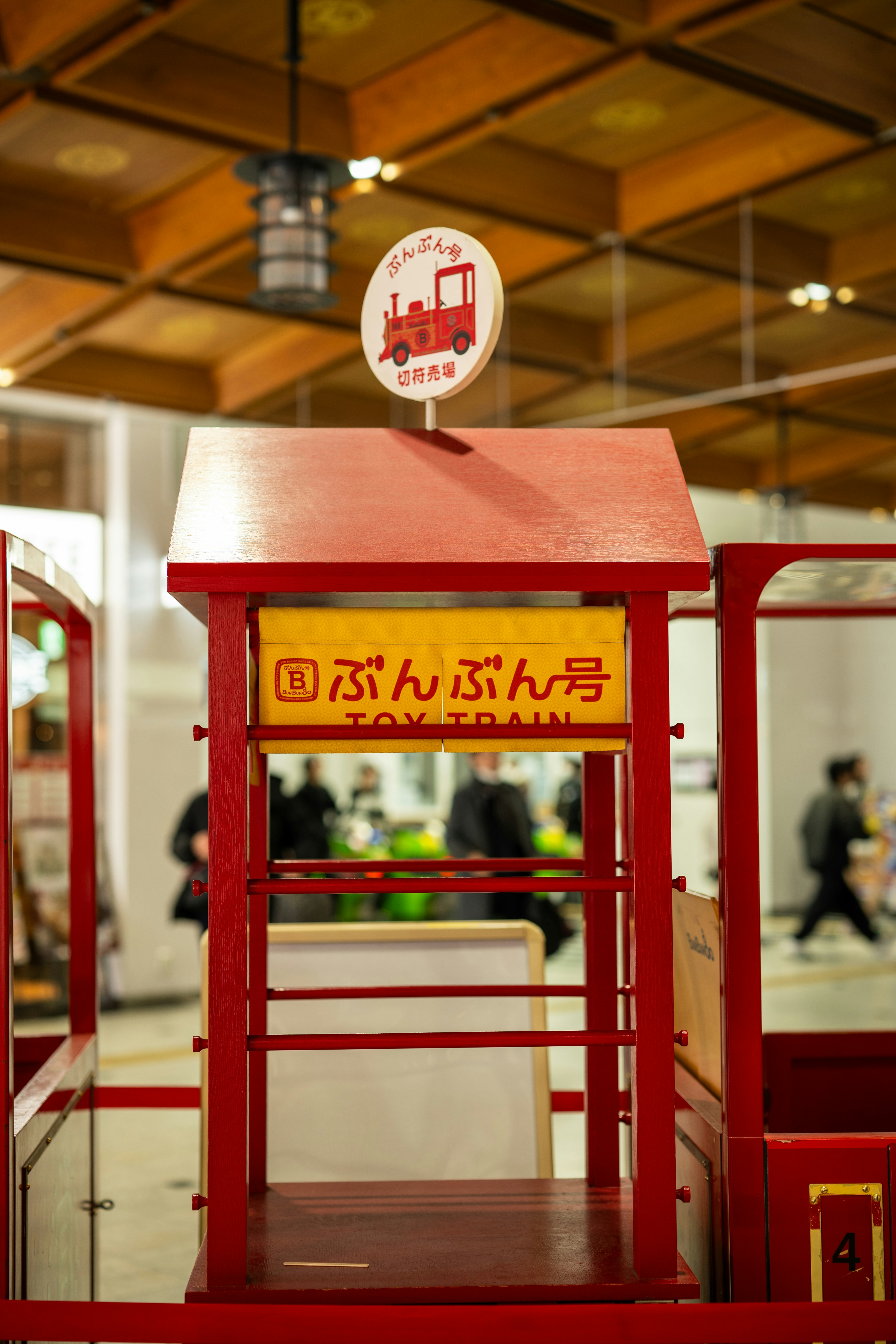 Red Miniature Train Stand in a Busy Indoor Market
