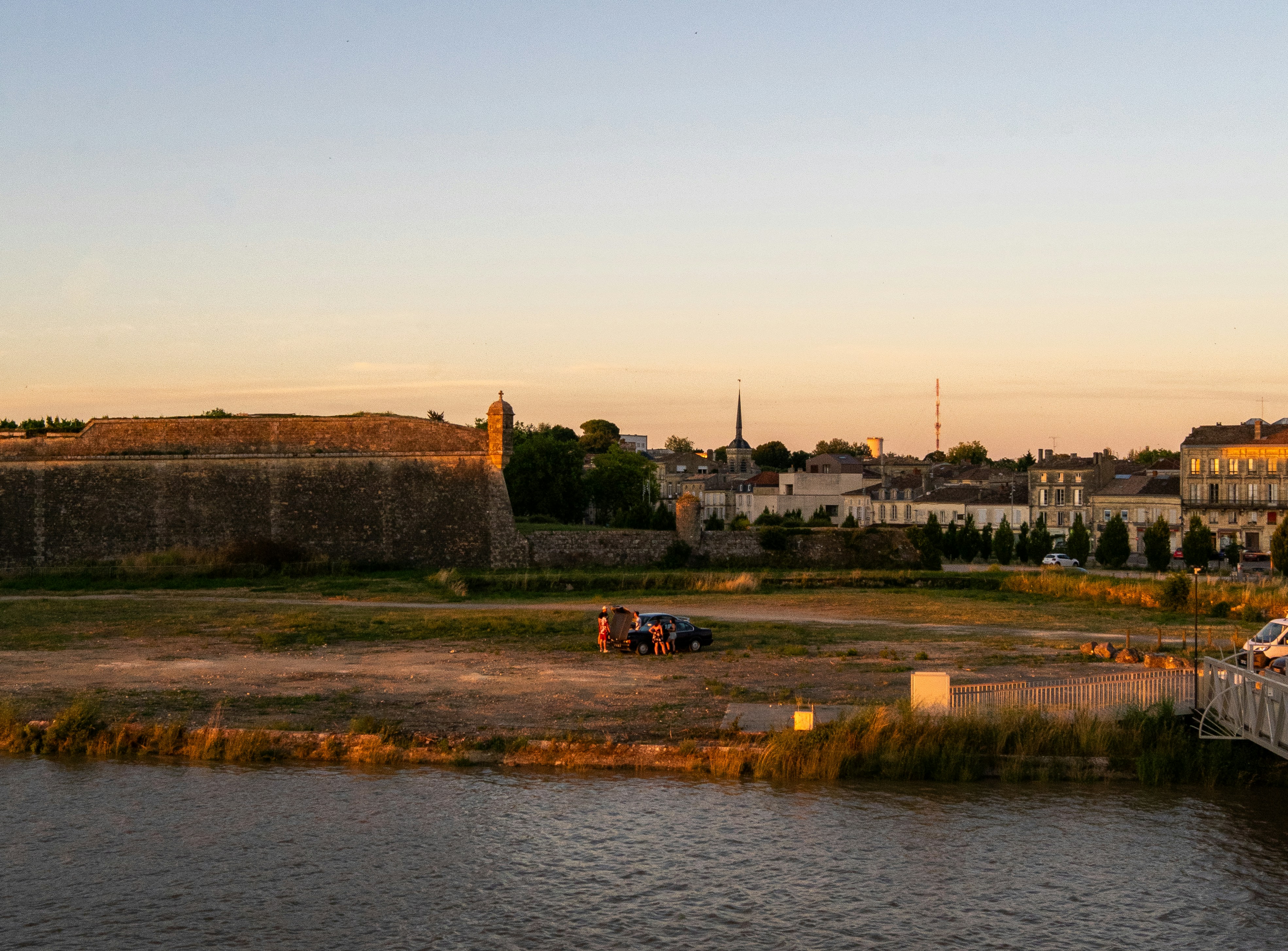 Sunlit Riverside Camp by the Ancient Wall