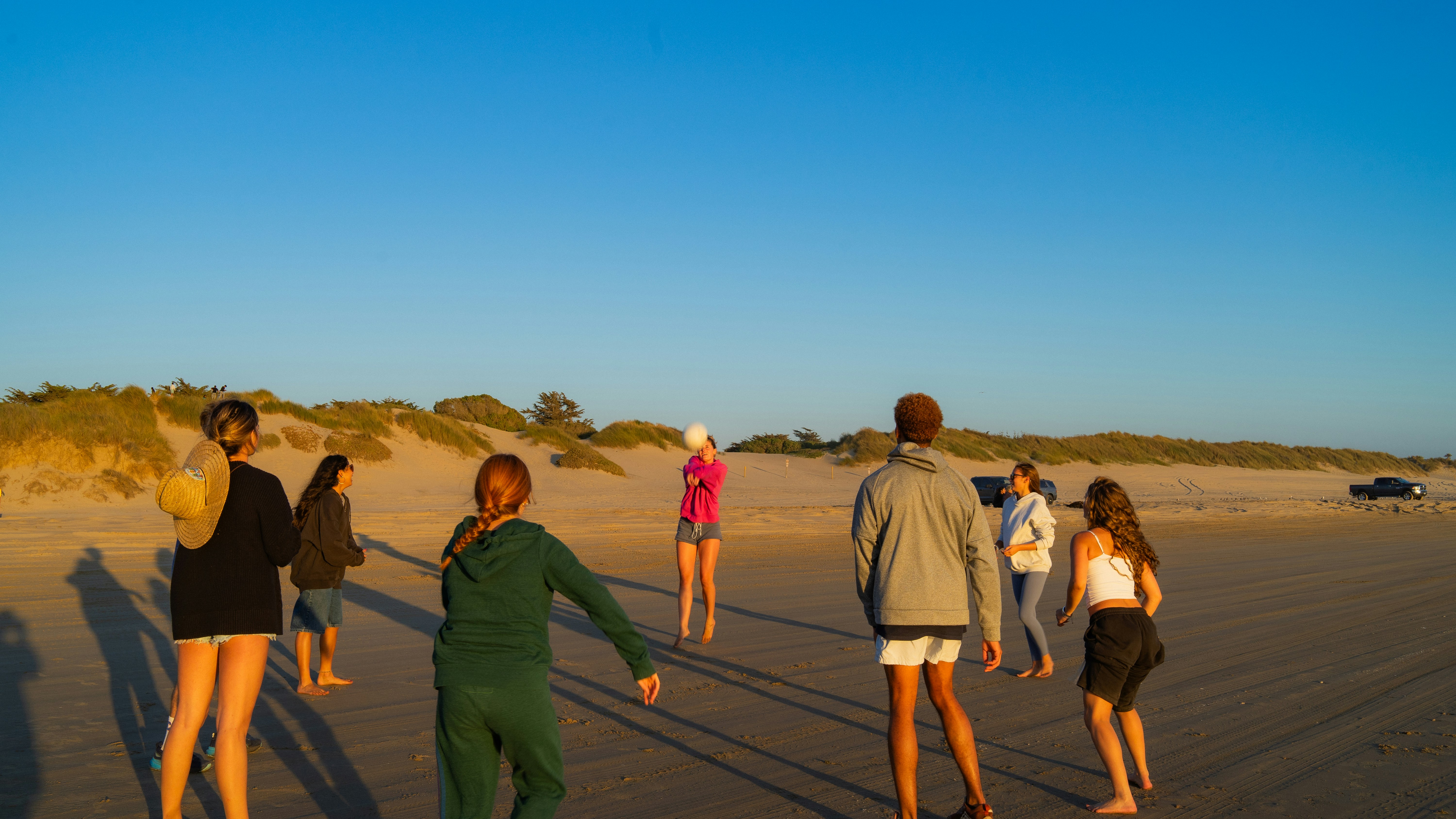 Sunlit Circle: Dune-side Group Portrait on a Deserted Beach