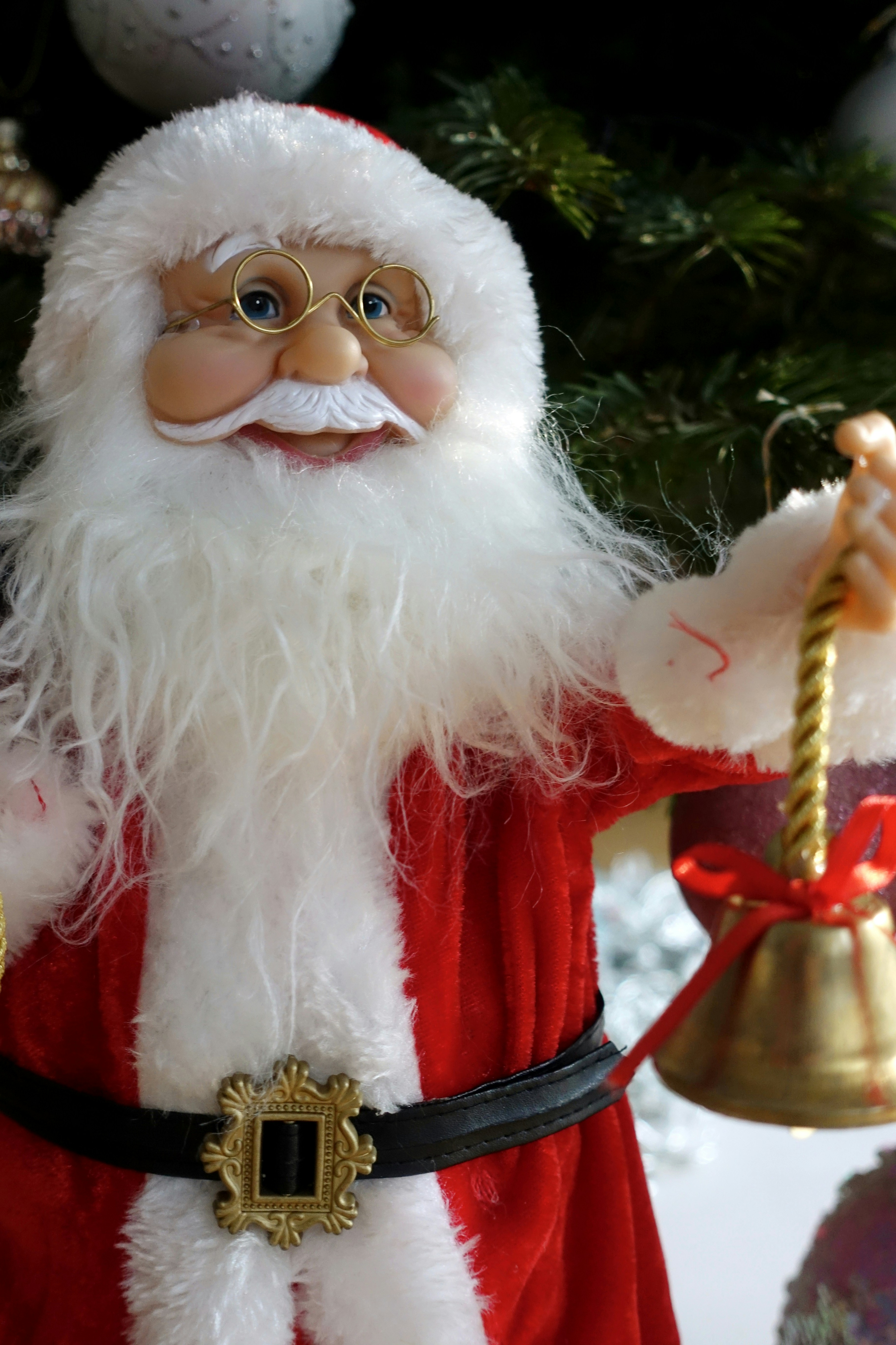 Santa claus holding a golden bell near a christmas tree. photo – Free ...