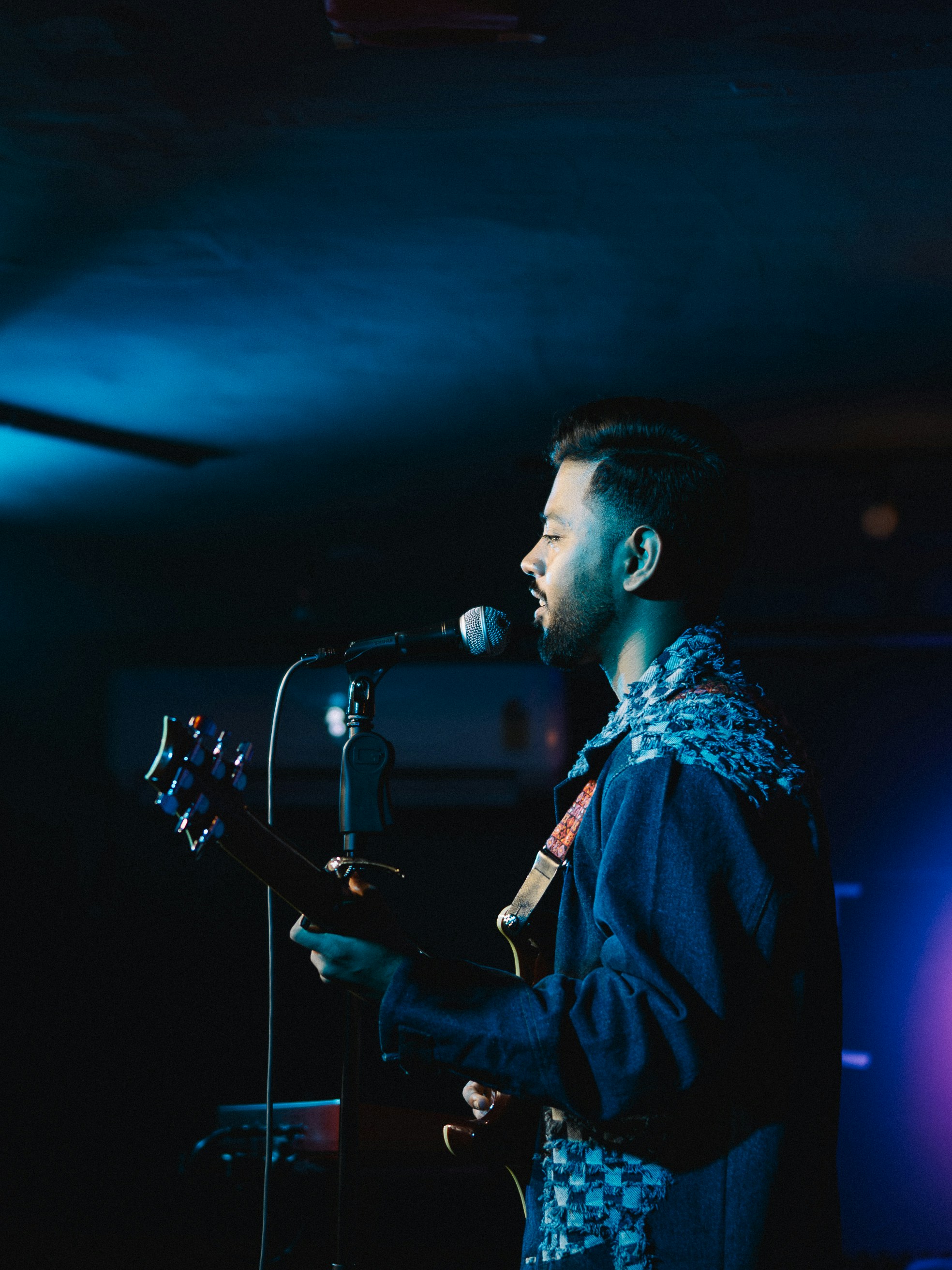 Man playing guitar and singing on stage photo – Free Microphone Image ...