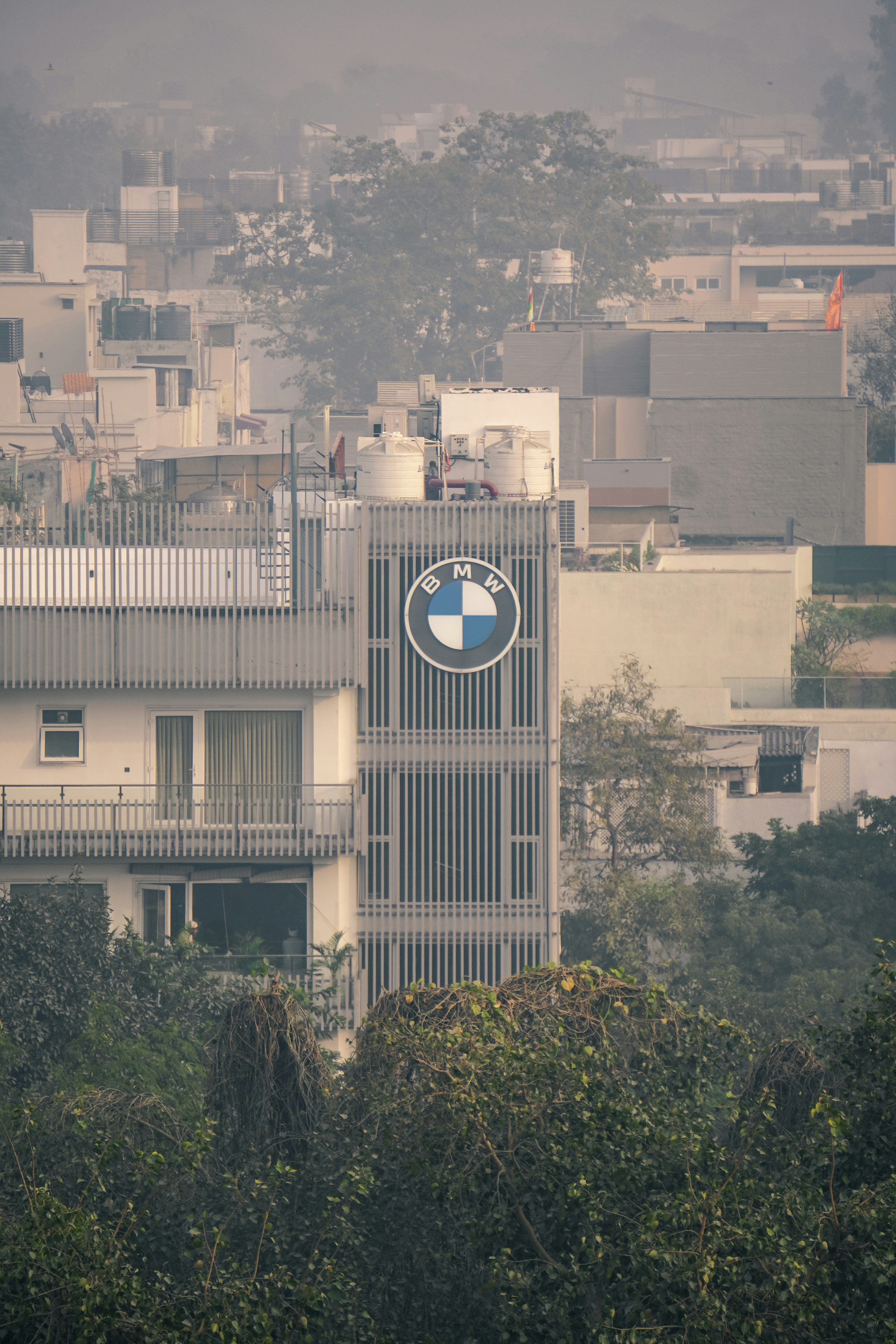 BMW emblem framed by urban silhouette and hazy skyline