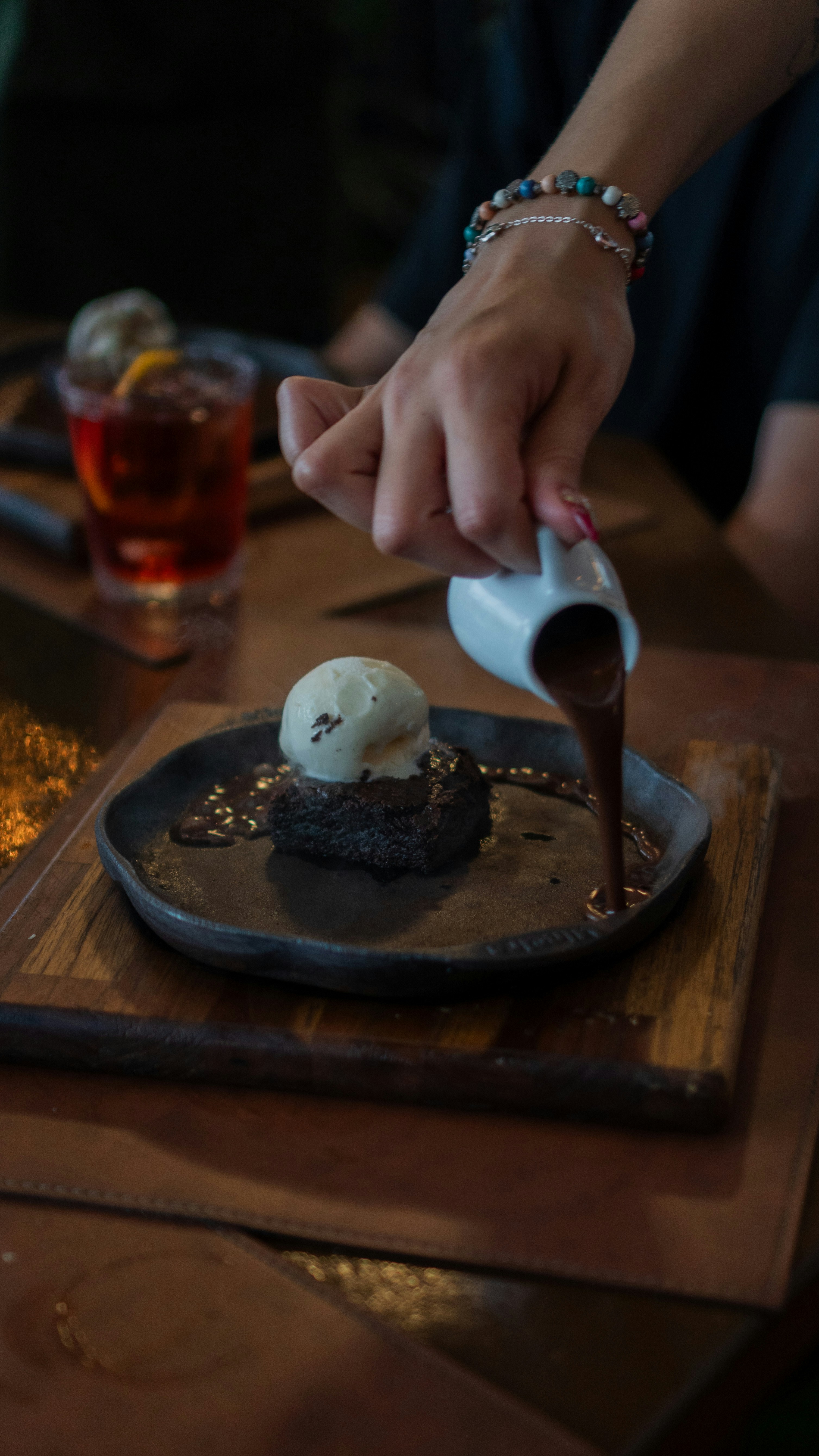 Echar salsa de chocolate sobre brownie con helado. foto – Imagen de ...