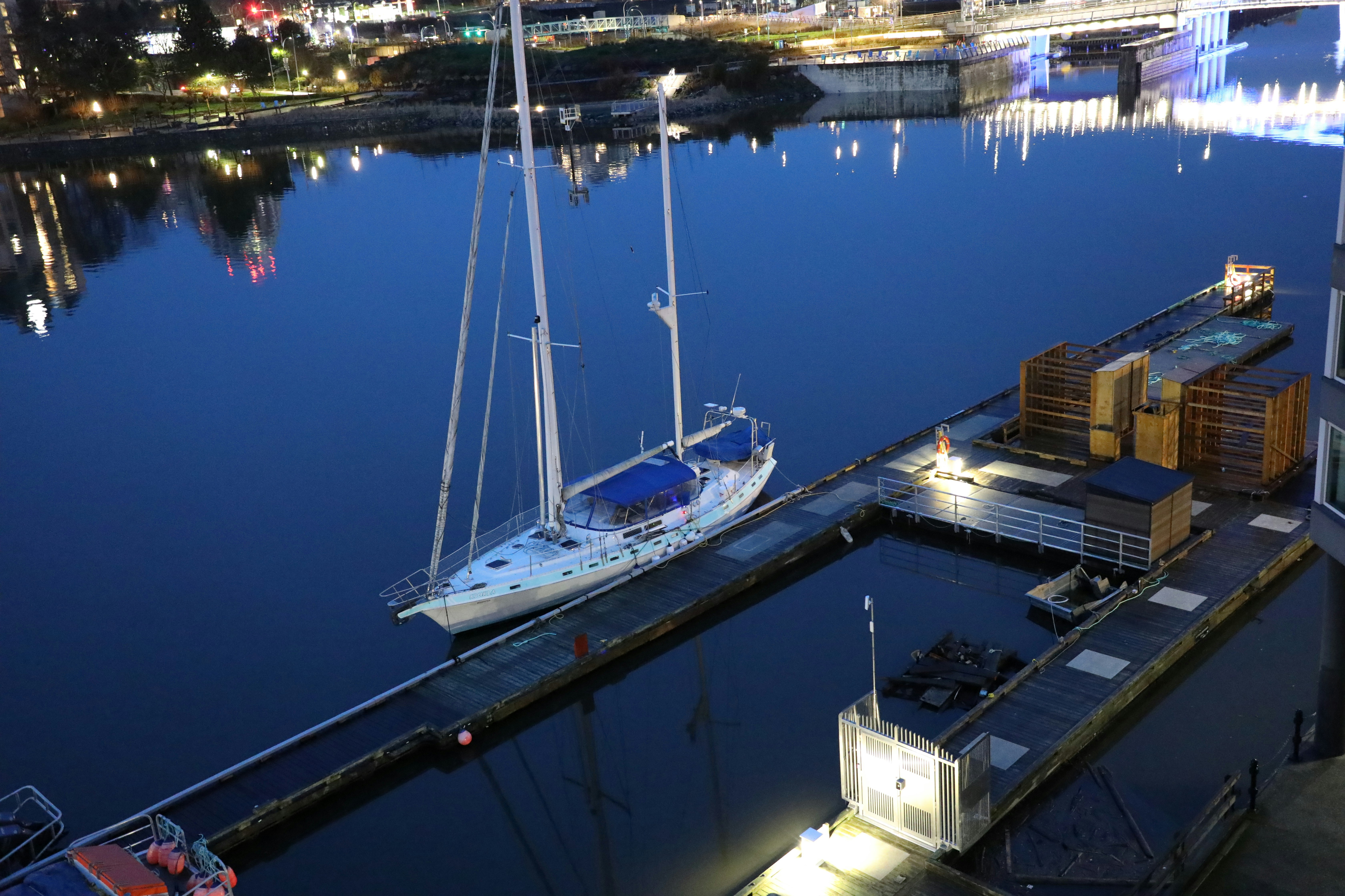 Moonlit Marina: A Sailboat Quietly Graced by Still Waters