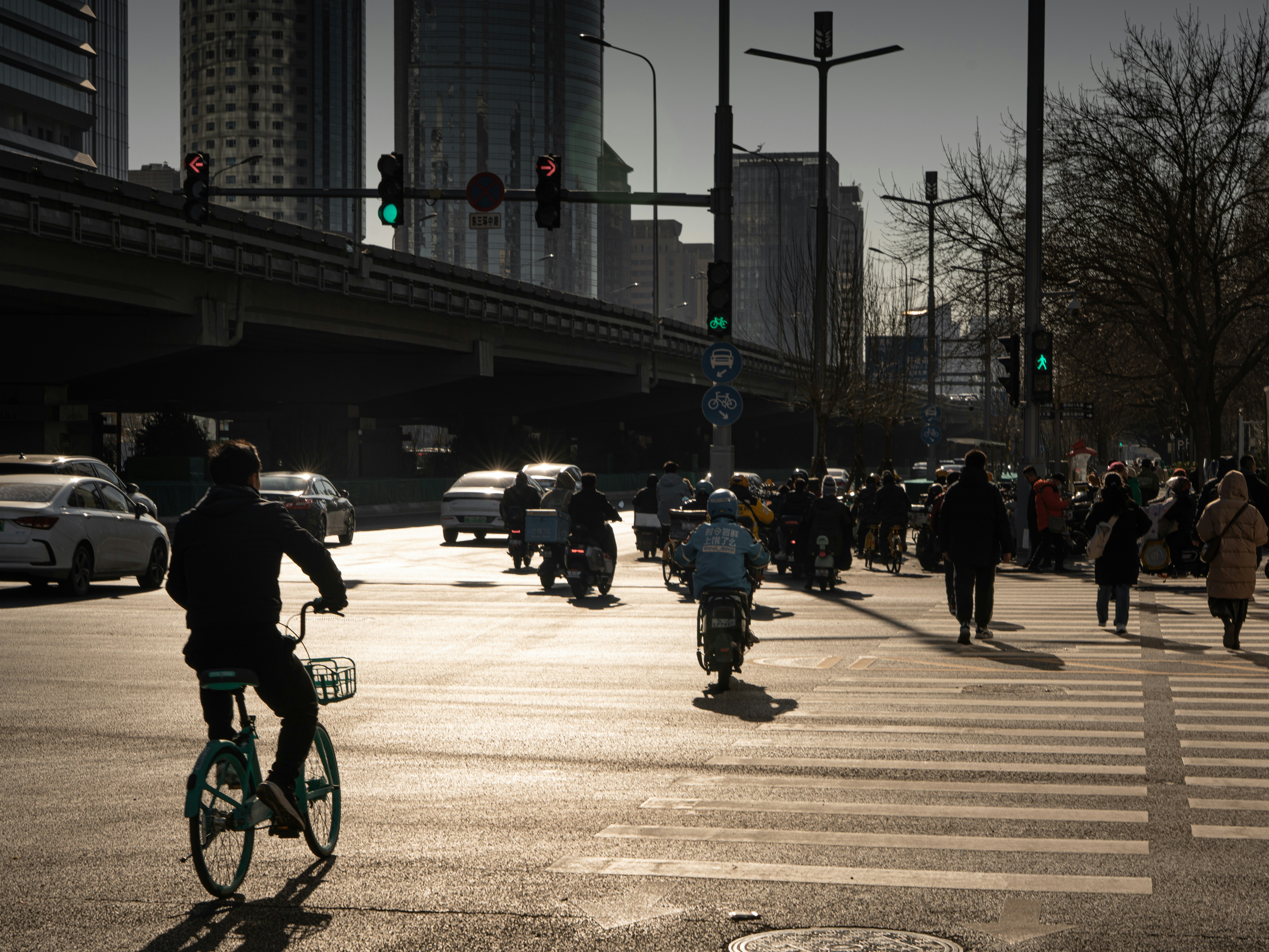 Des personnes et des véhicules traversent un carrefour très fréquenté ...