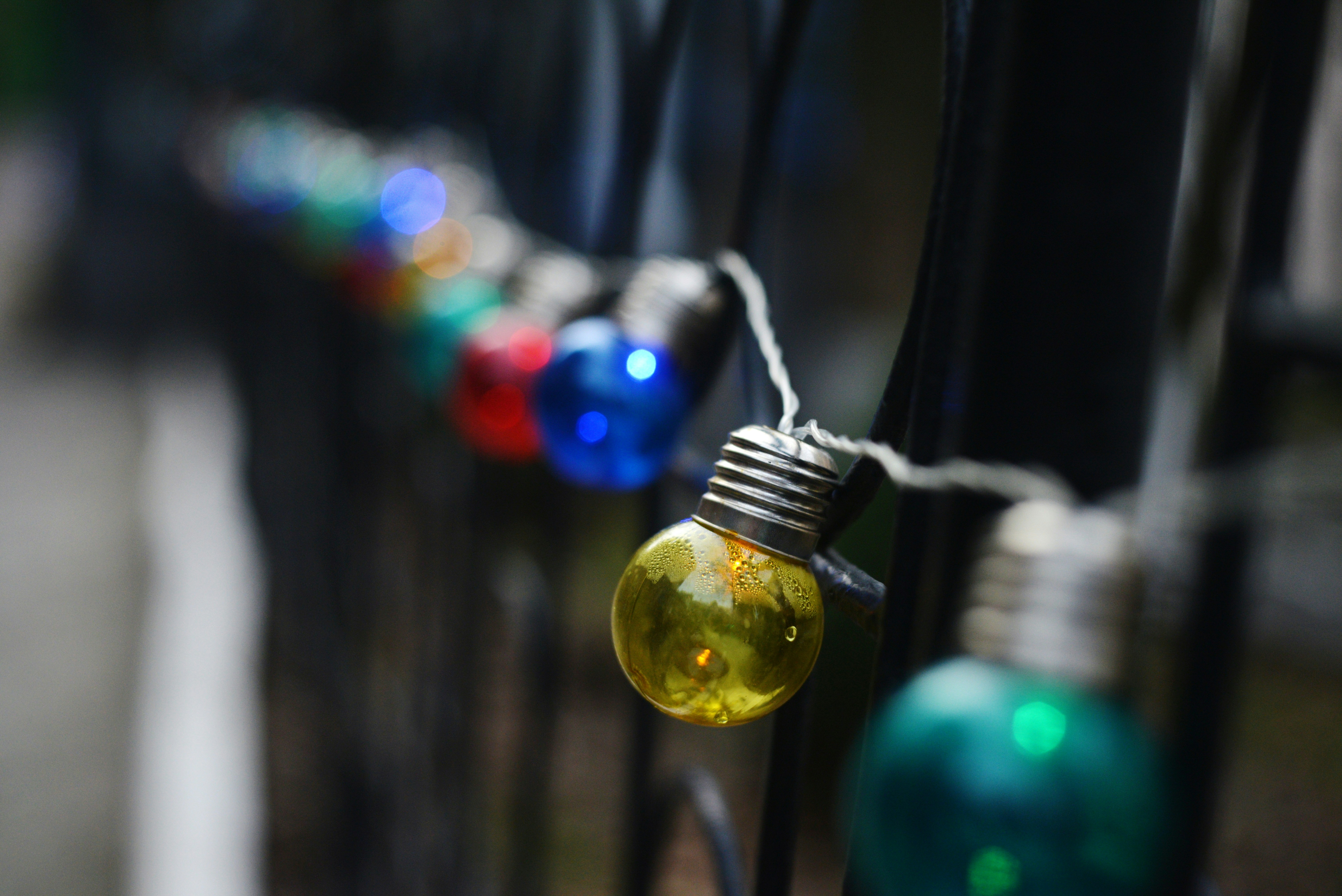 Glowing Christmas Orbs: A Row of Bokeh Bulbs along a Fence