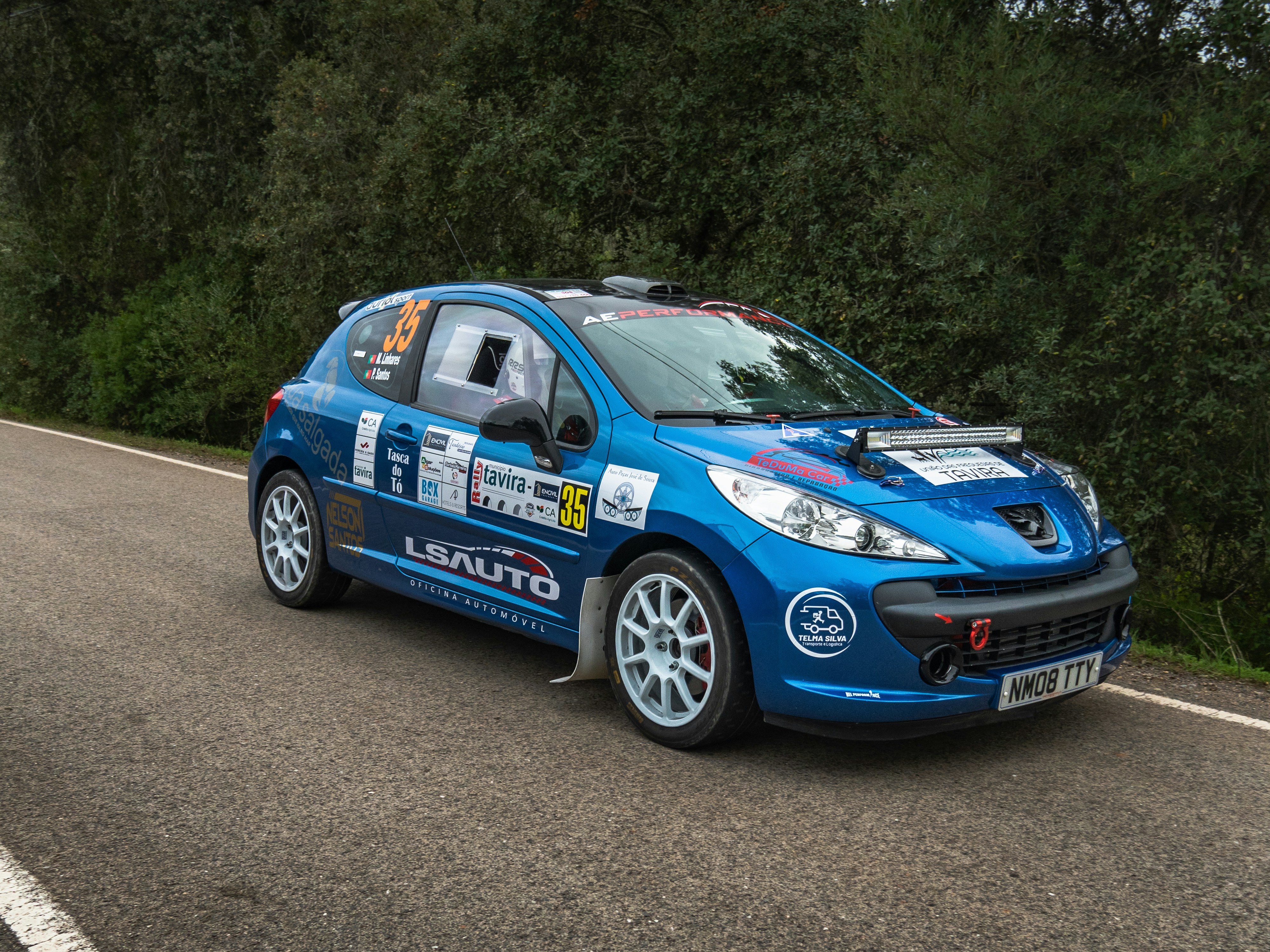Blue rally car crouched on the road, ready for the next downhill sprint