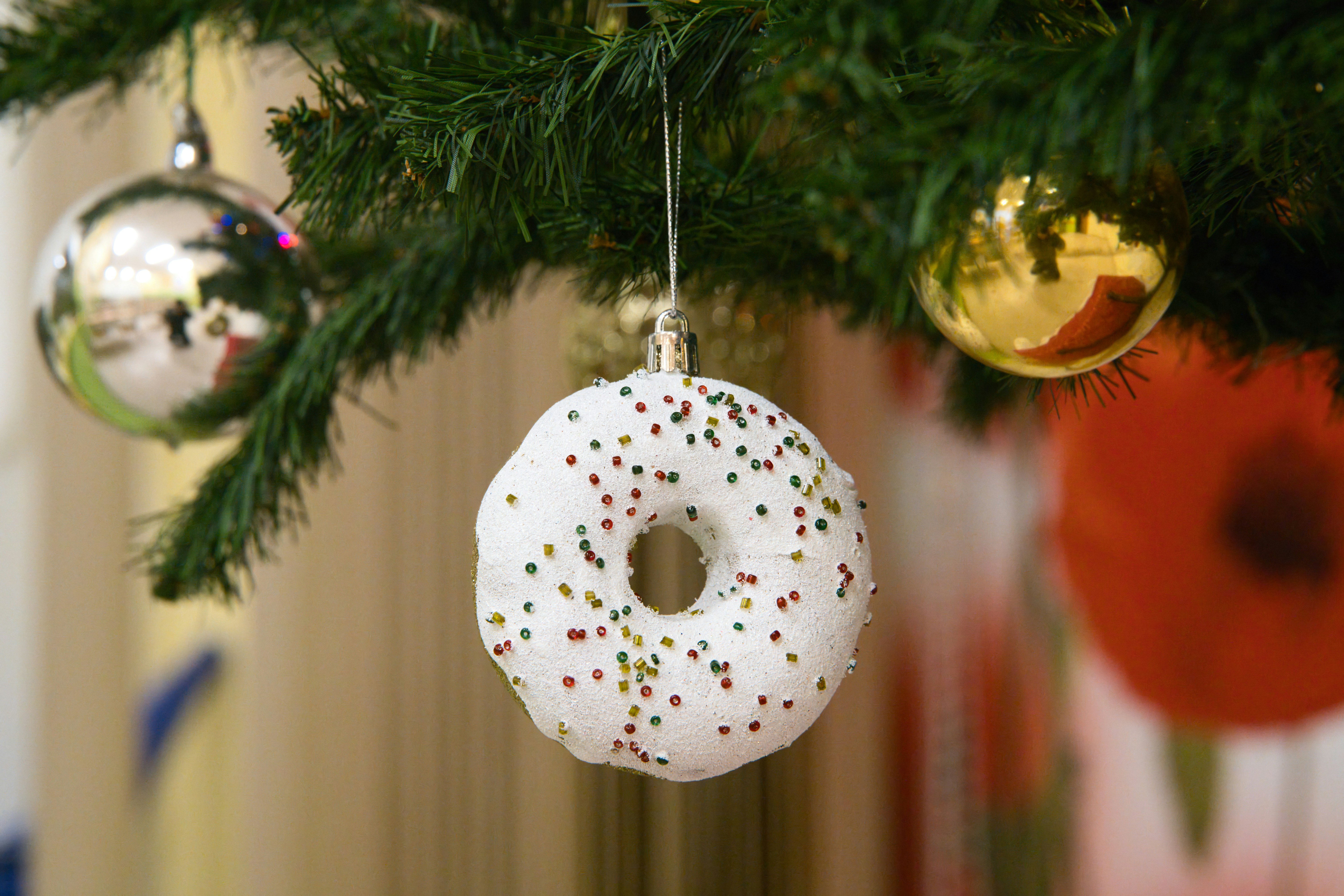 A Sprinkle-Dusted Donut Ornament Adorns a Christmas Tree