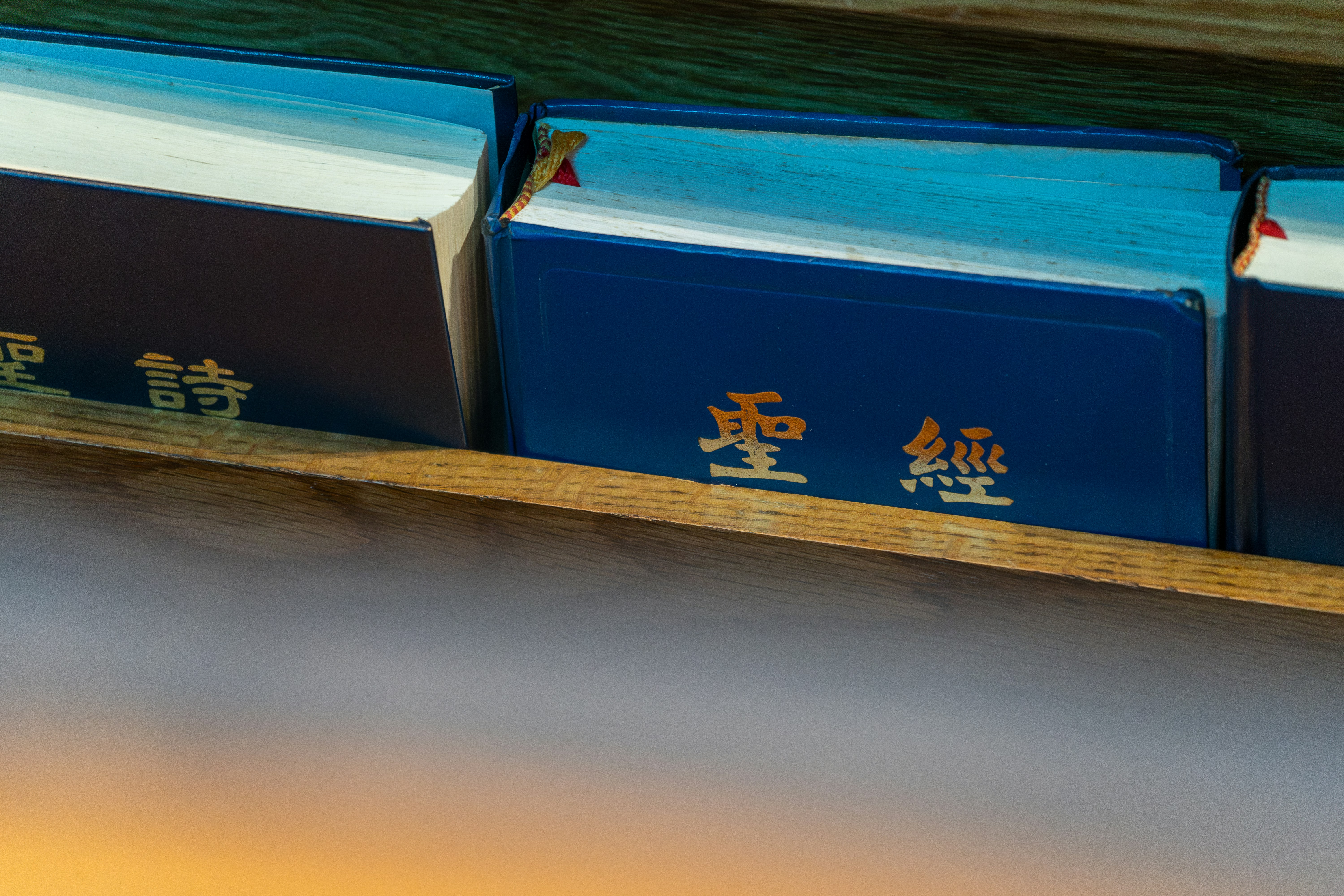Blue-bound Wisdom: A row of religious texts in a wooden rack