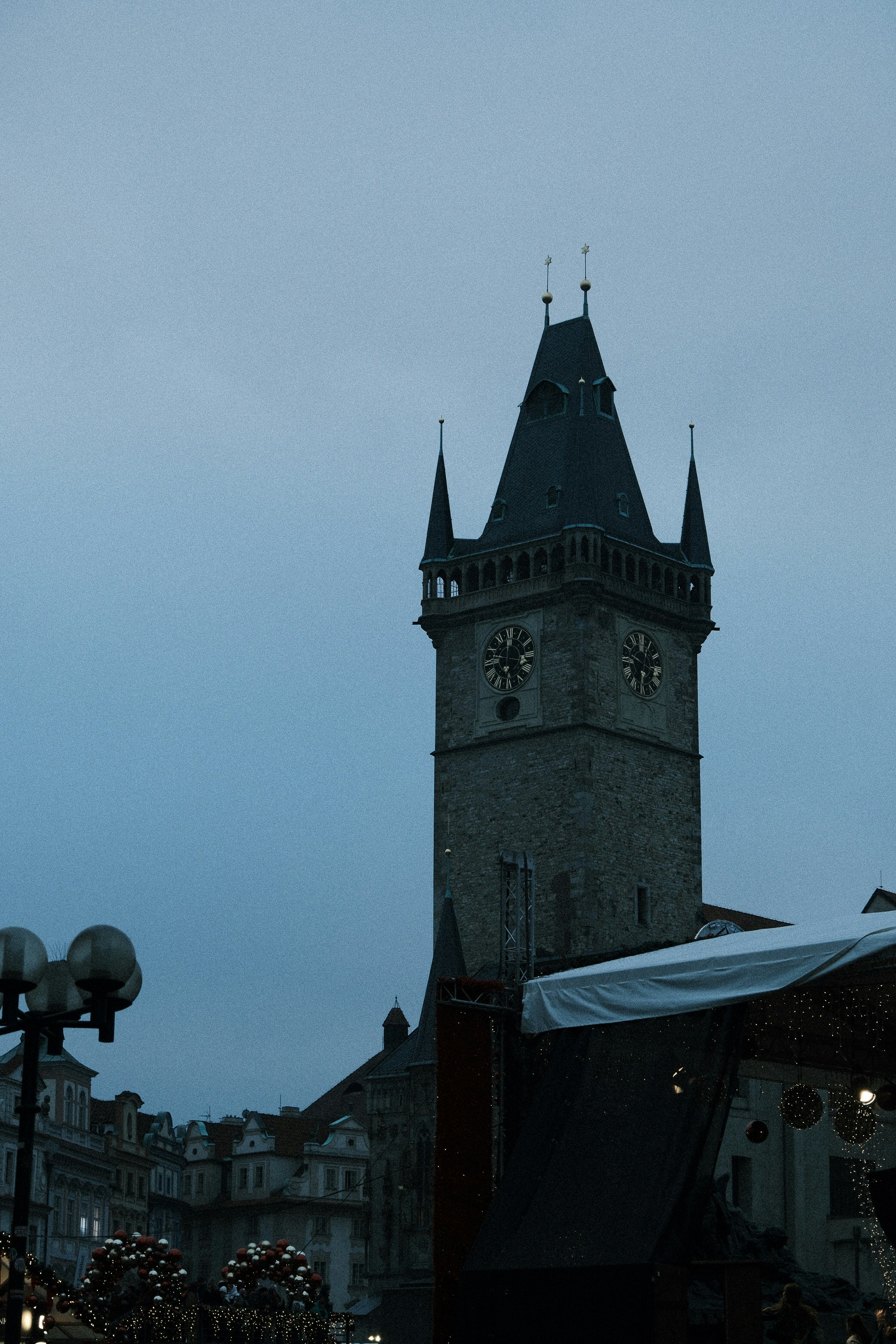Tower at Dusk: Clock Tower Silhouette Over a Holiday Market