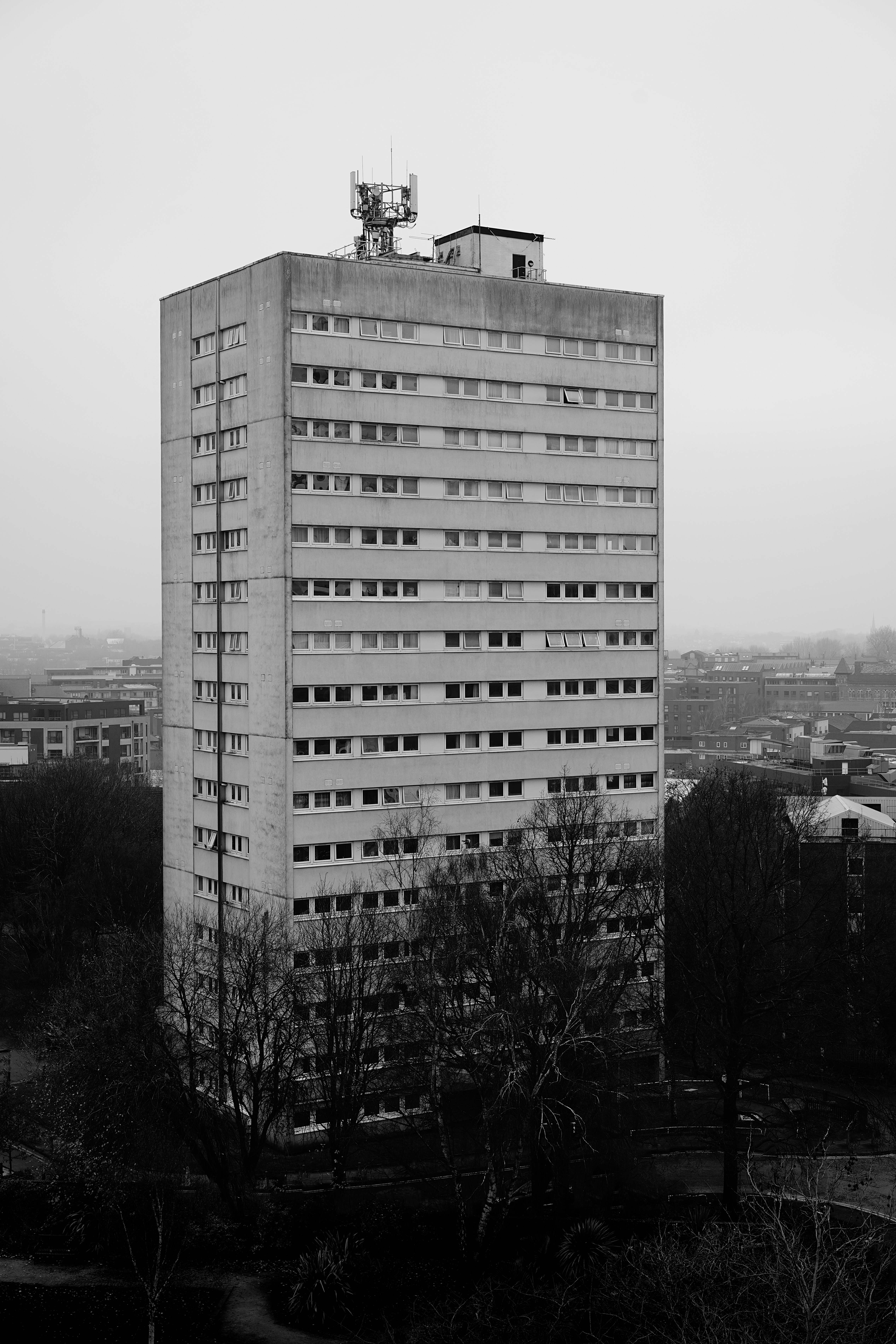 A tall concrete apartment building with many windows. photo – Free City ...