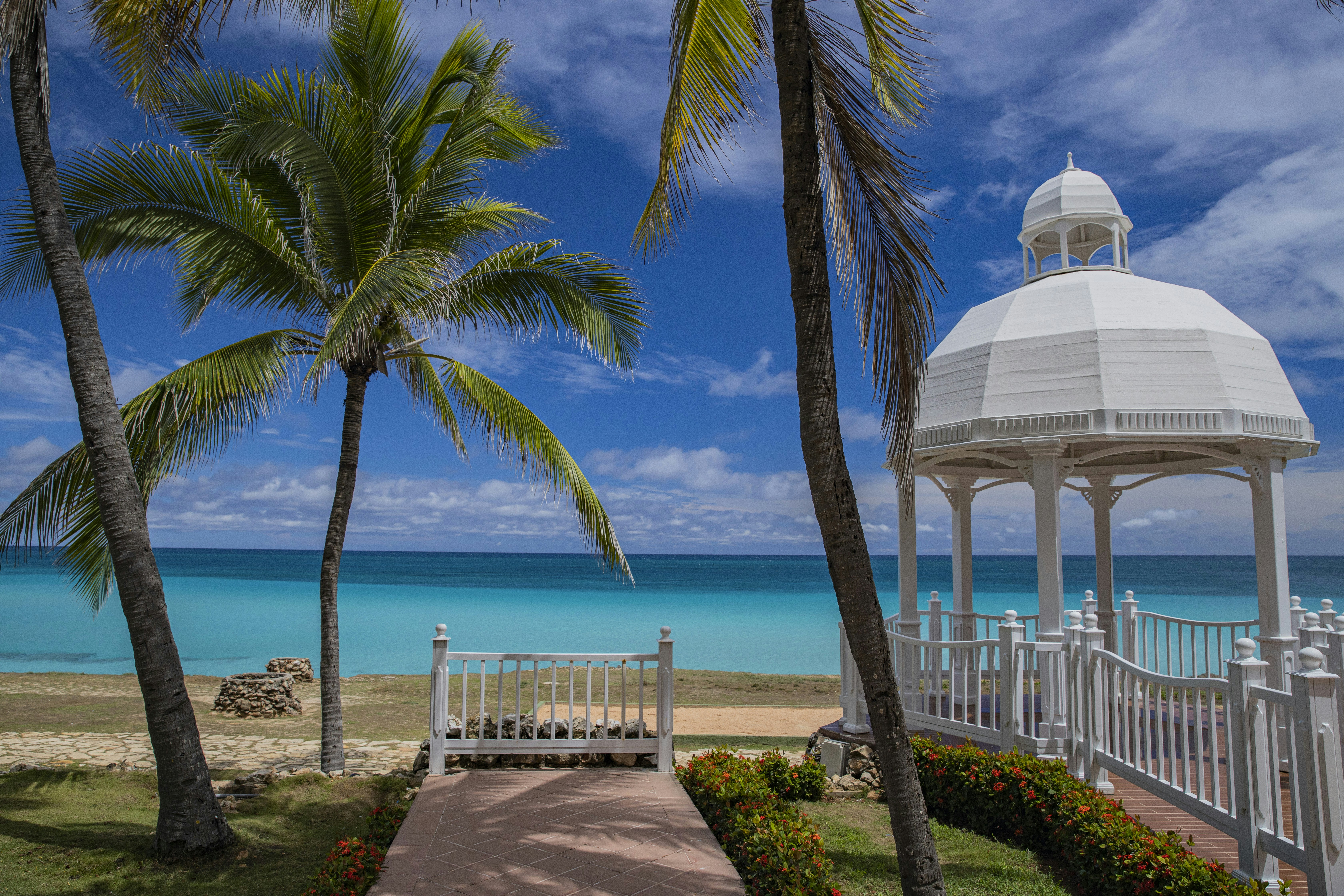 White Gazebo at the End of the Palm-Fringed Beach Path
