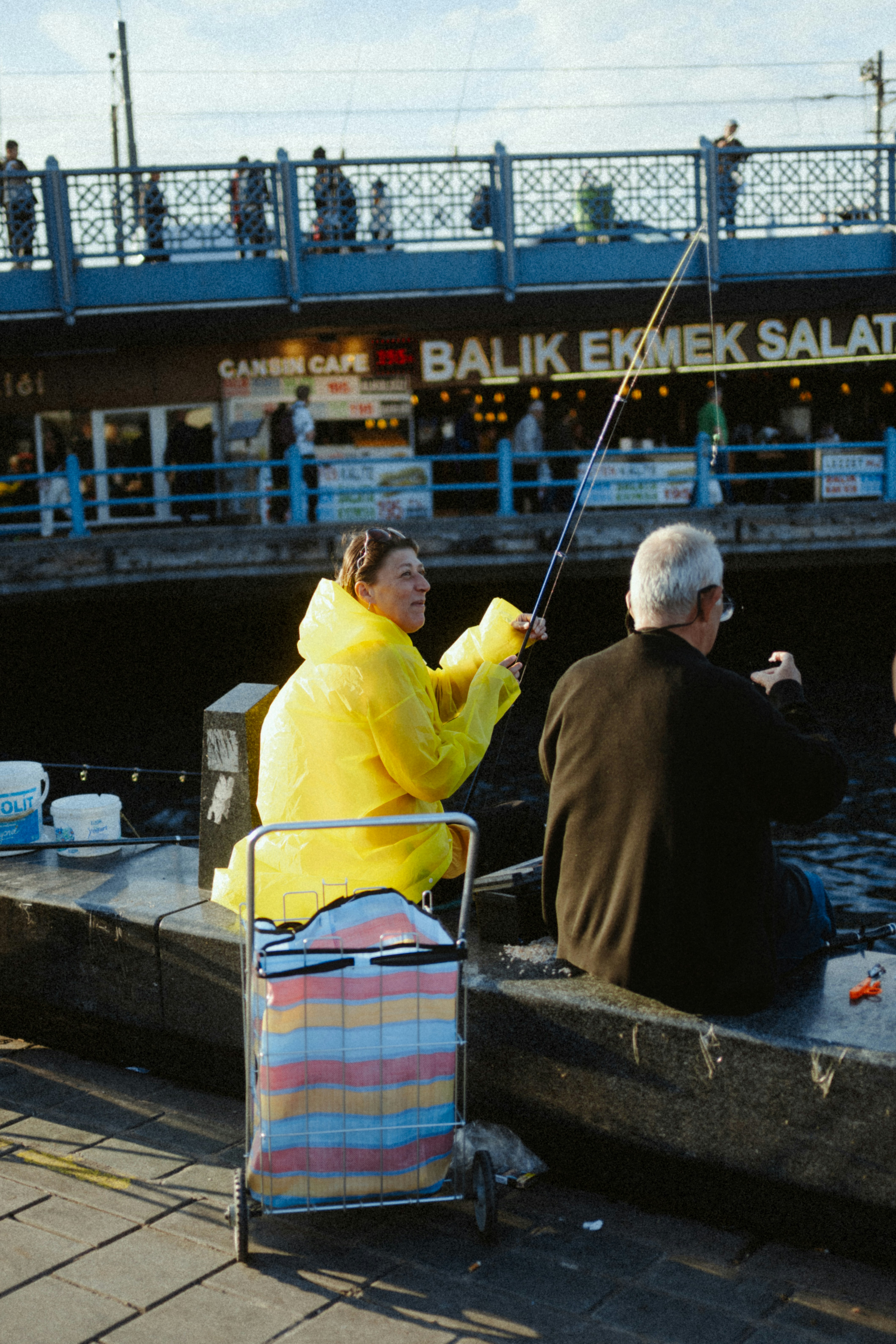Yellow Raincoat Stance: Angling for a Catch by the Waterfront