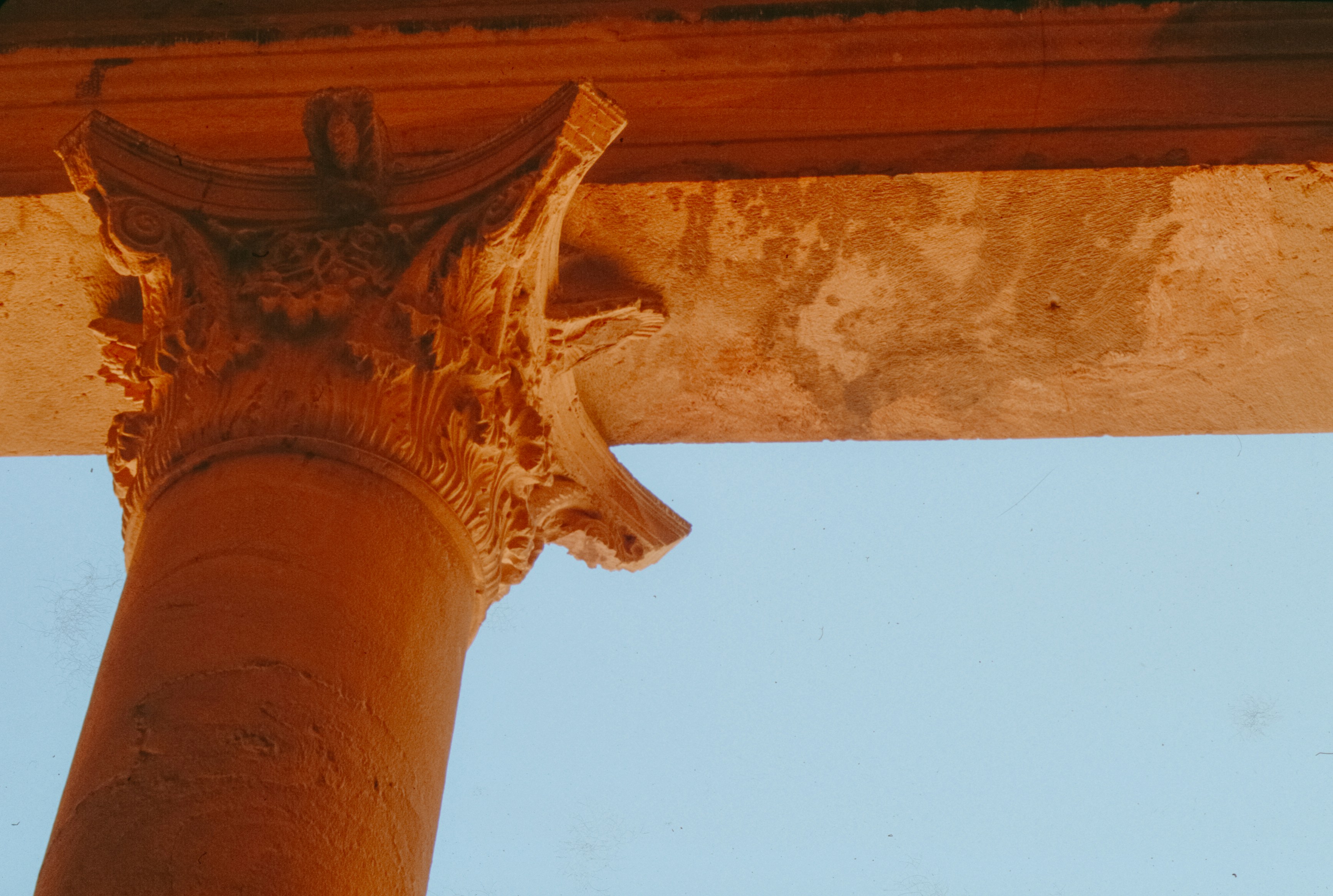 Close-up of an ancient column against blue sky.