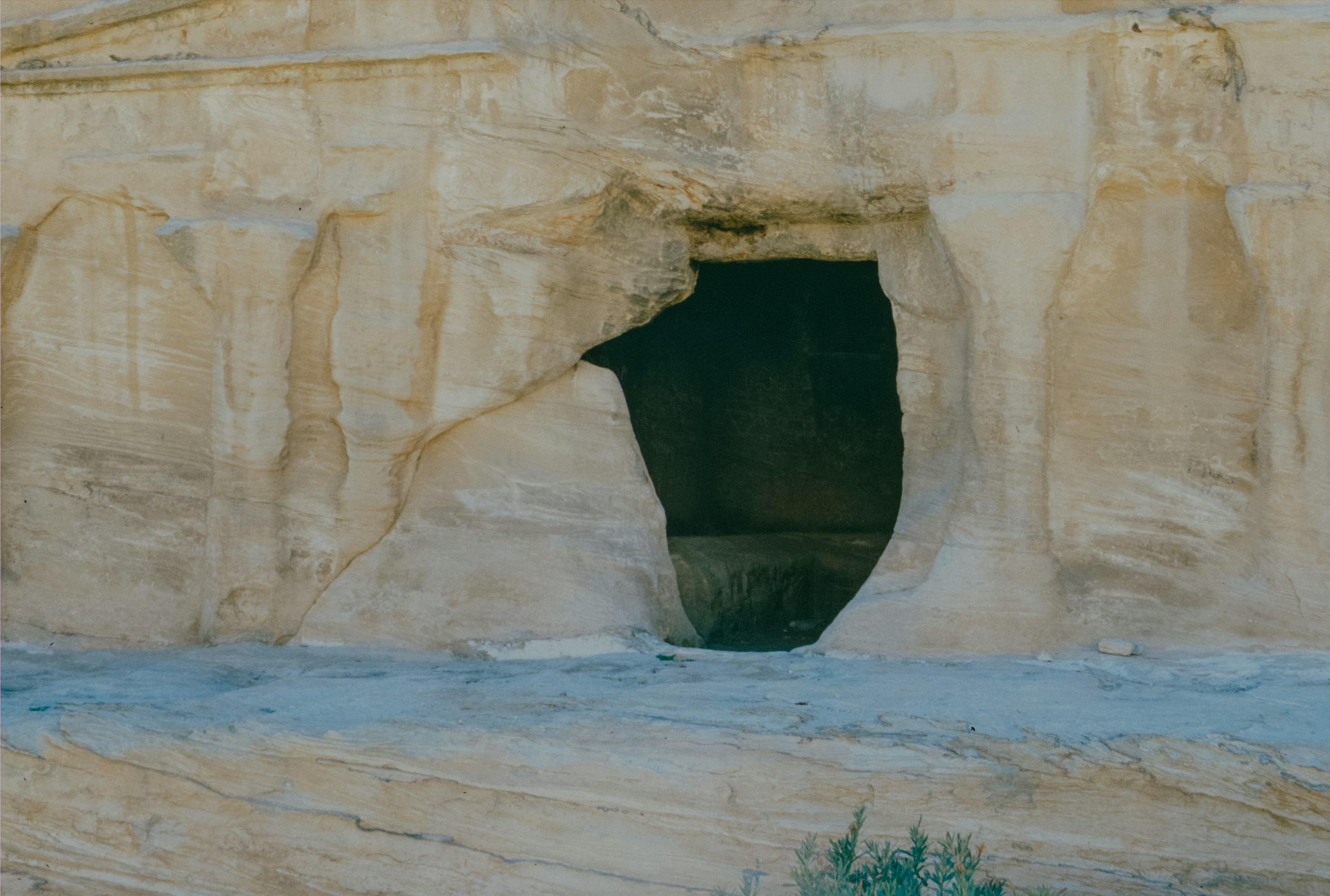 Entrance to a cave carved into sandstone cliffs