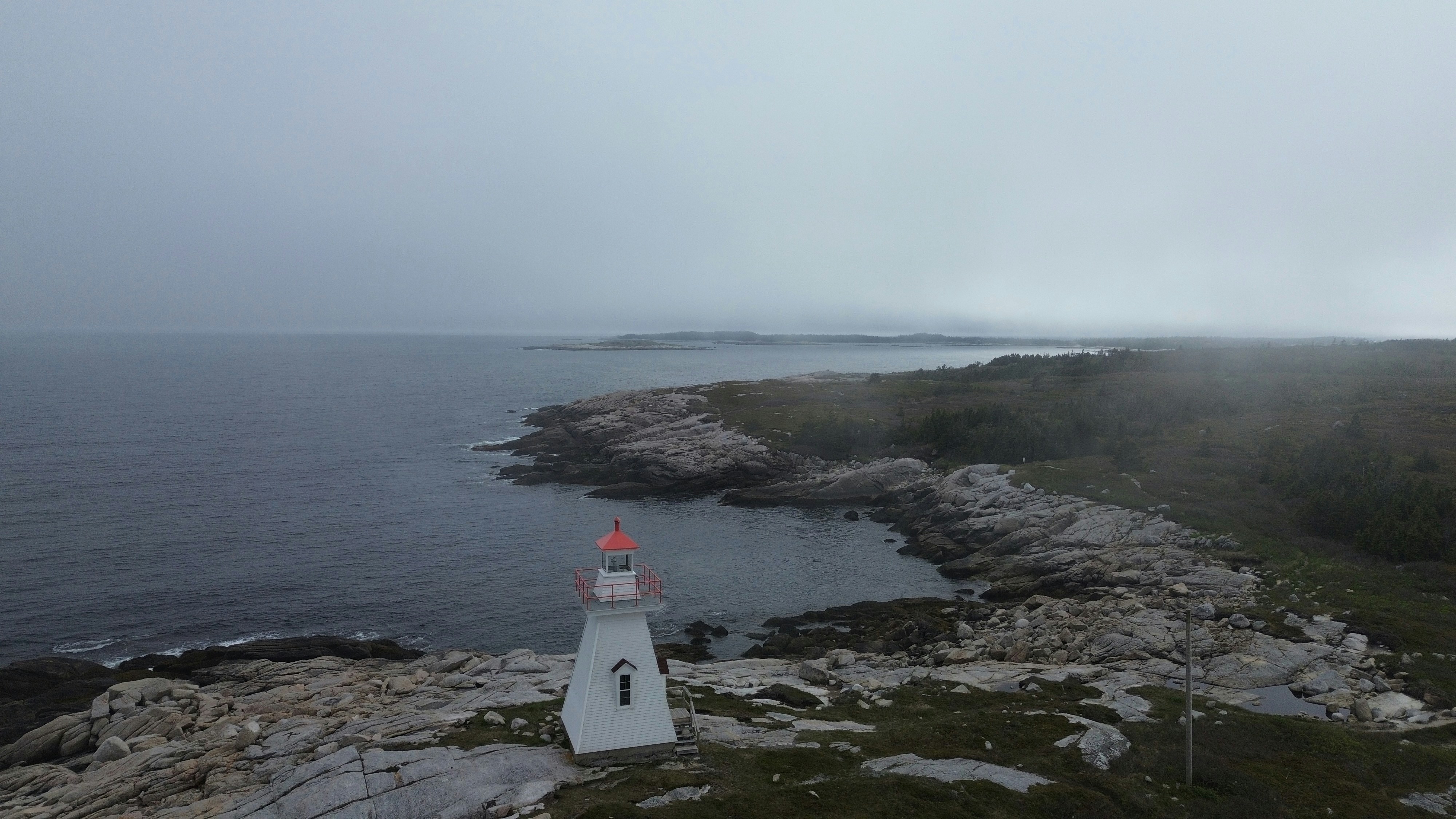 Beacon at the Edge: A Quiet Lighthouse Amid Rugged Shore