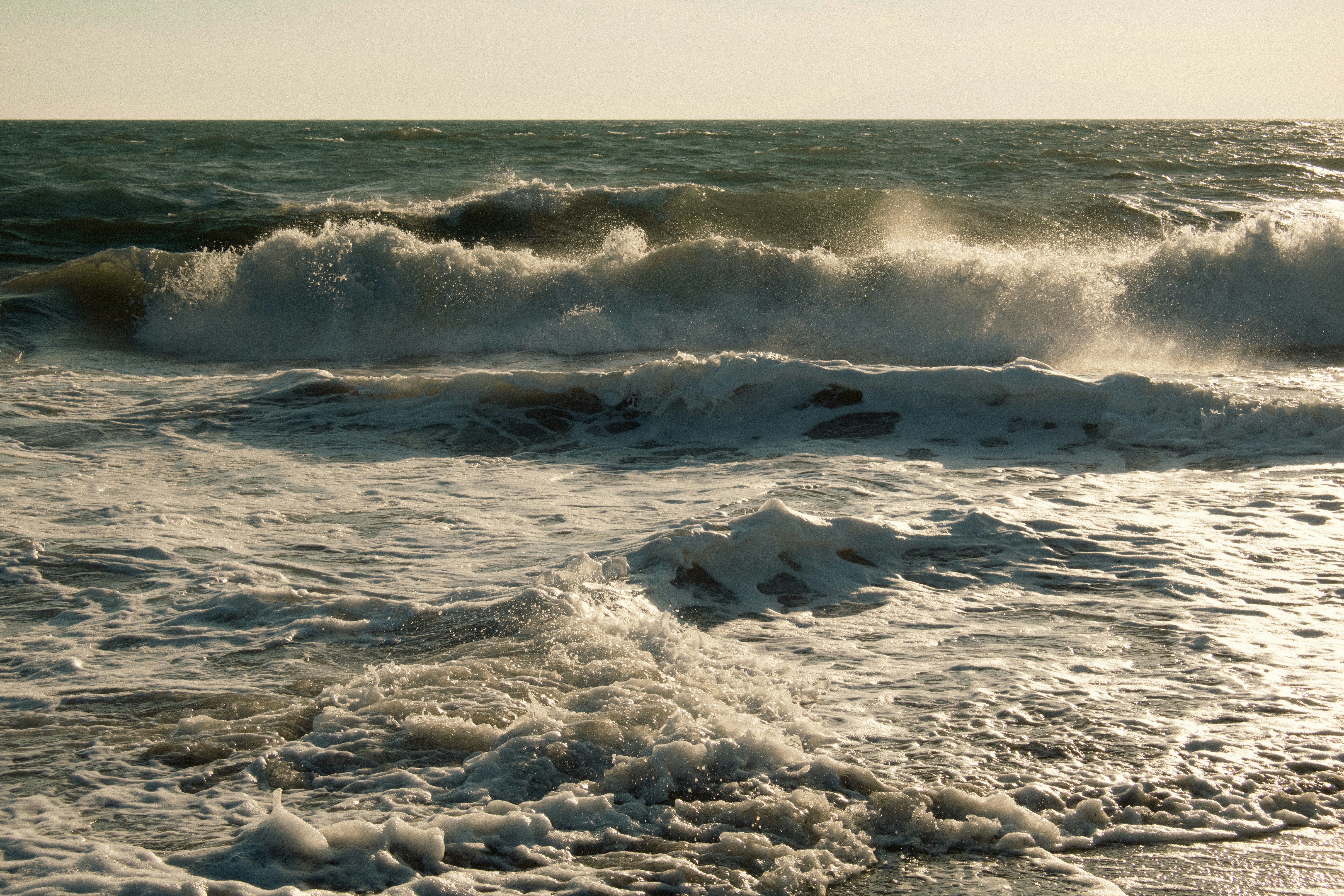Crashing Atlantic Crest: Sunlit Foam Over Rolling Breakers