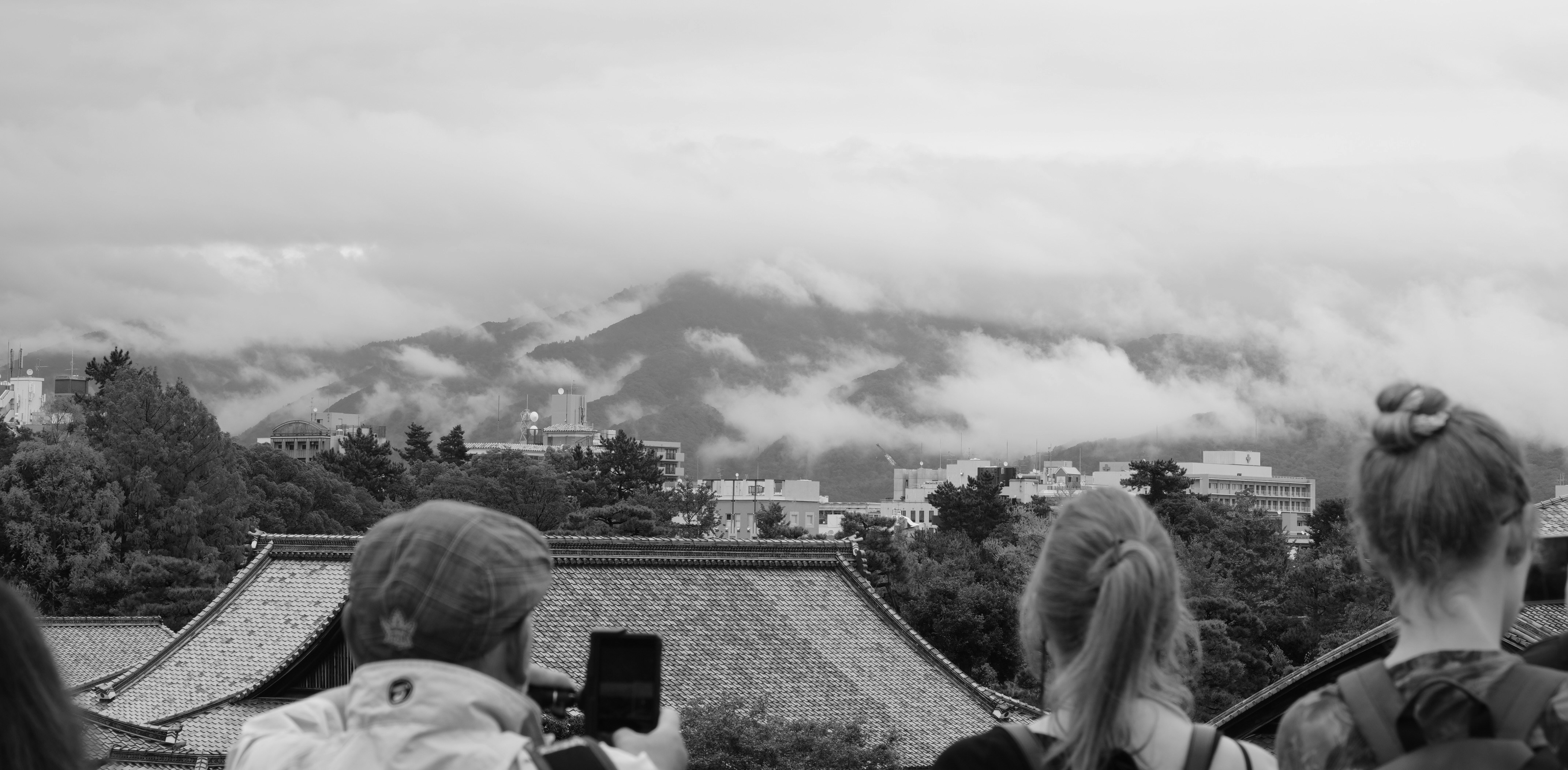 Overlook on the Terrace: People Capturing the Distant Mountains