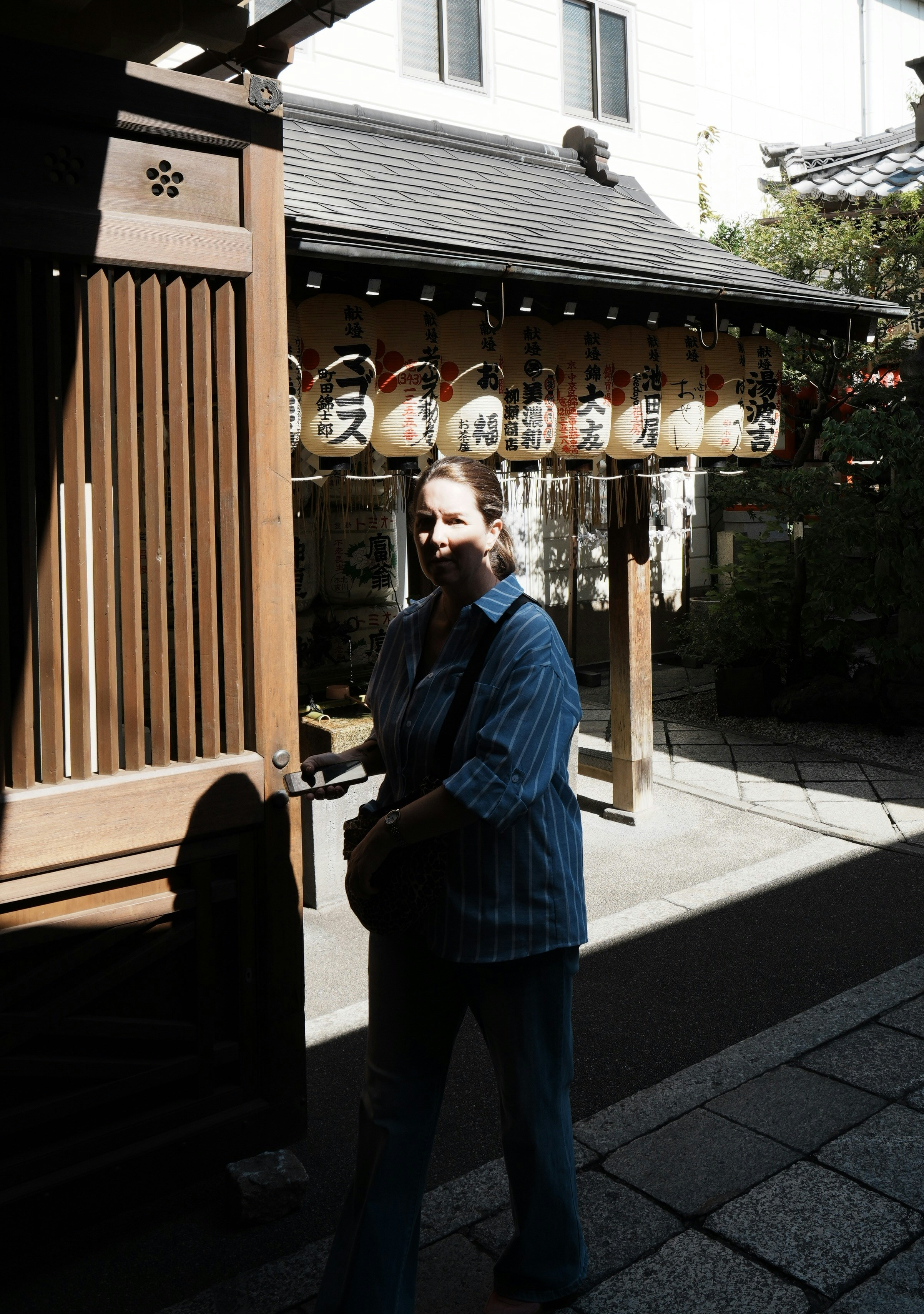 Blue-Jacketed Visitor at a Lantern-Decked Gate