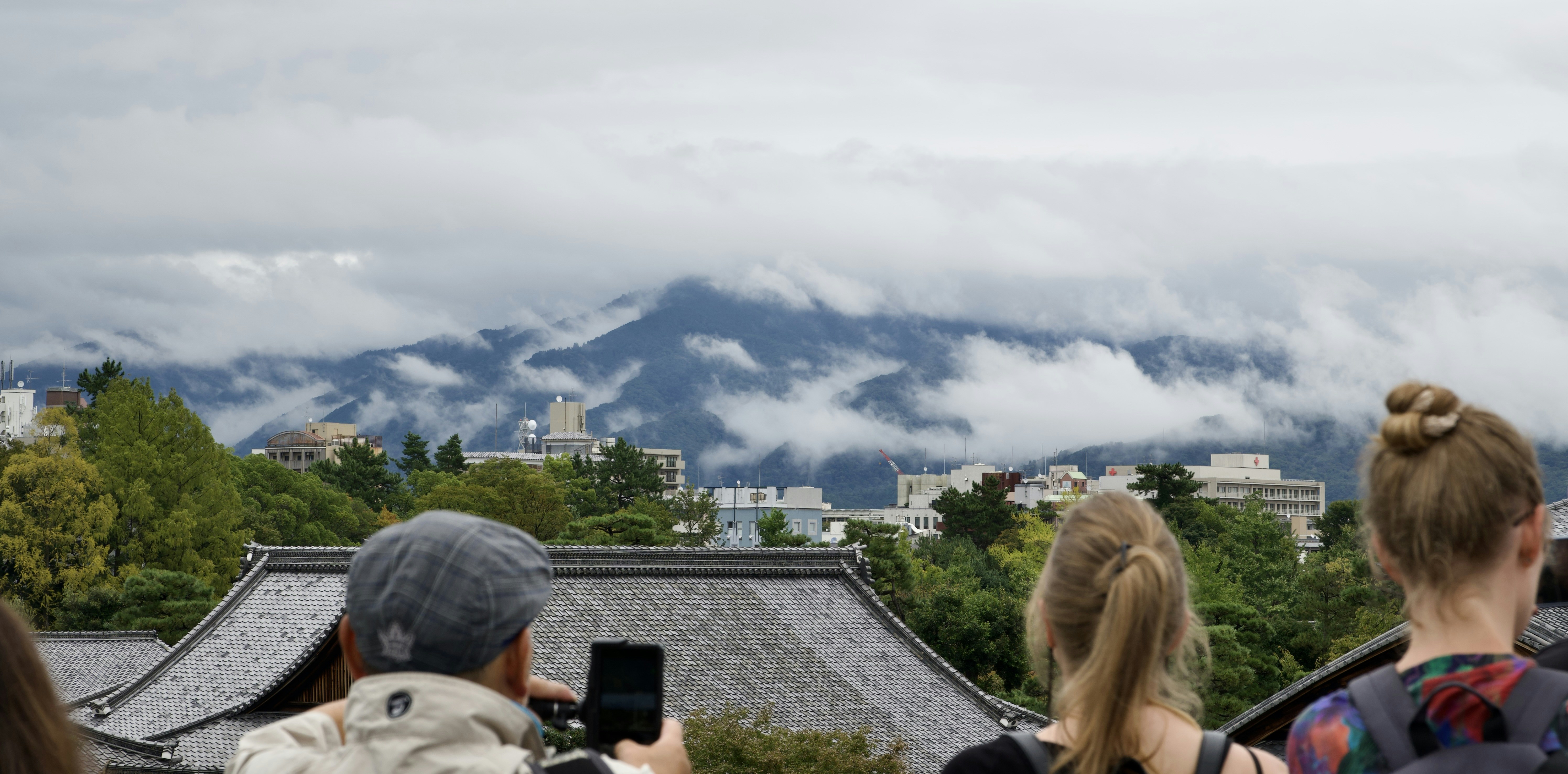 Clouds over Kyoto rooftops: spectators capture the moment