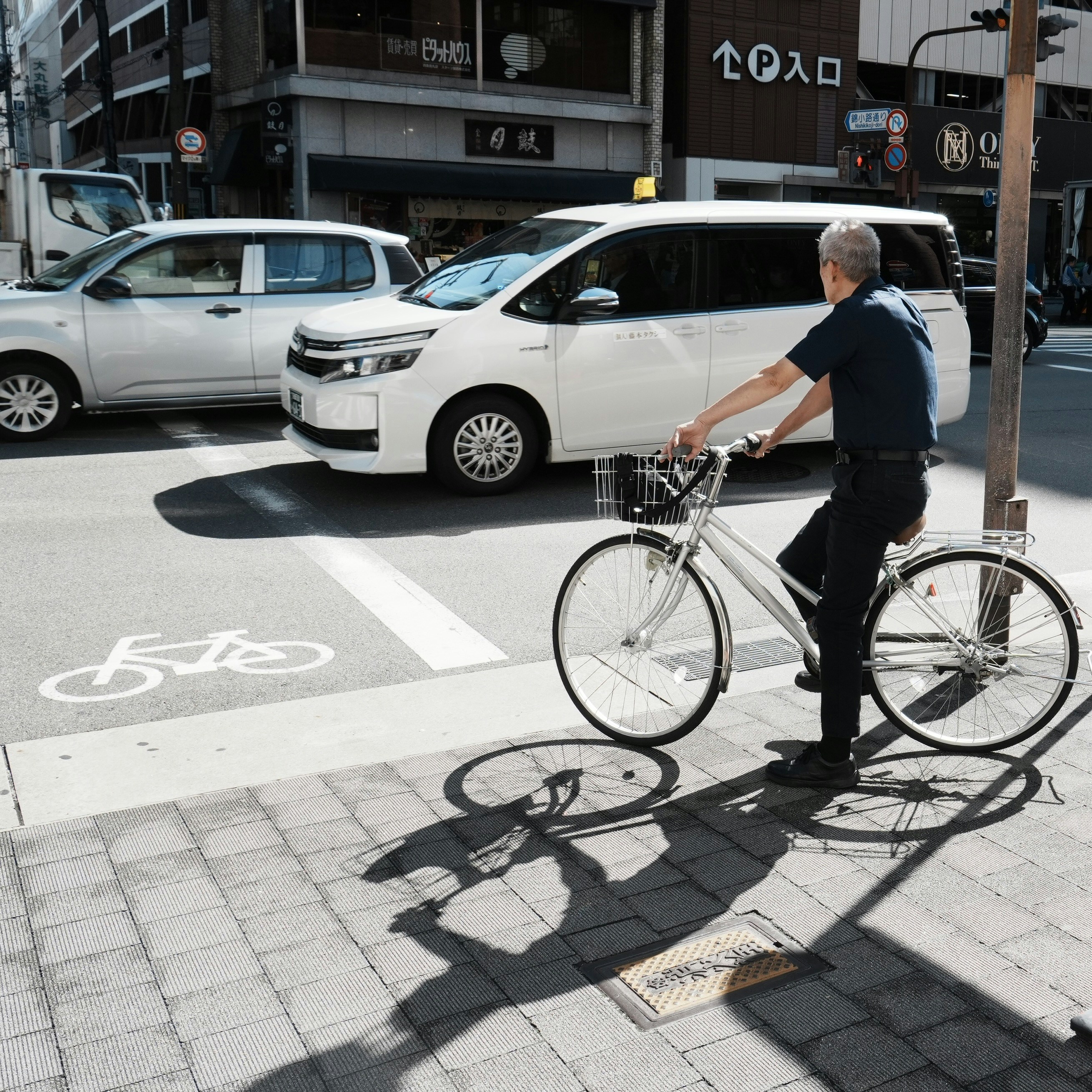 City Crossing: A Cyclist Paused at the Edge of Traffic