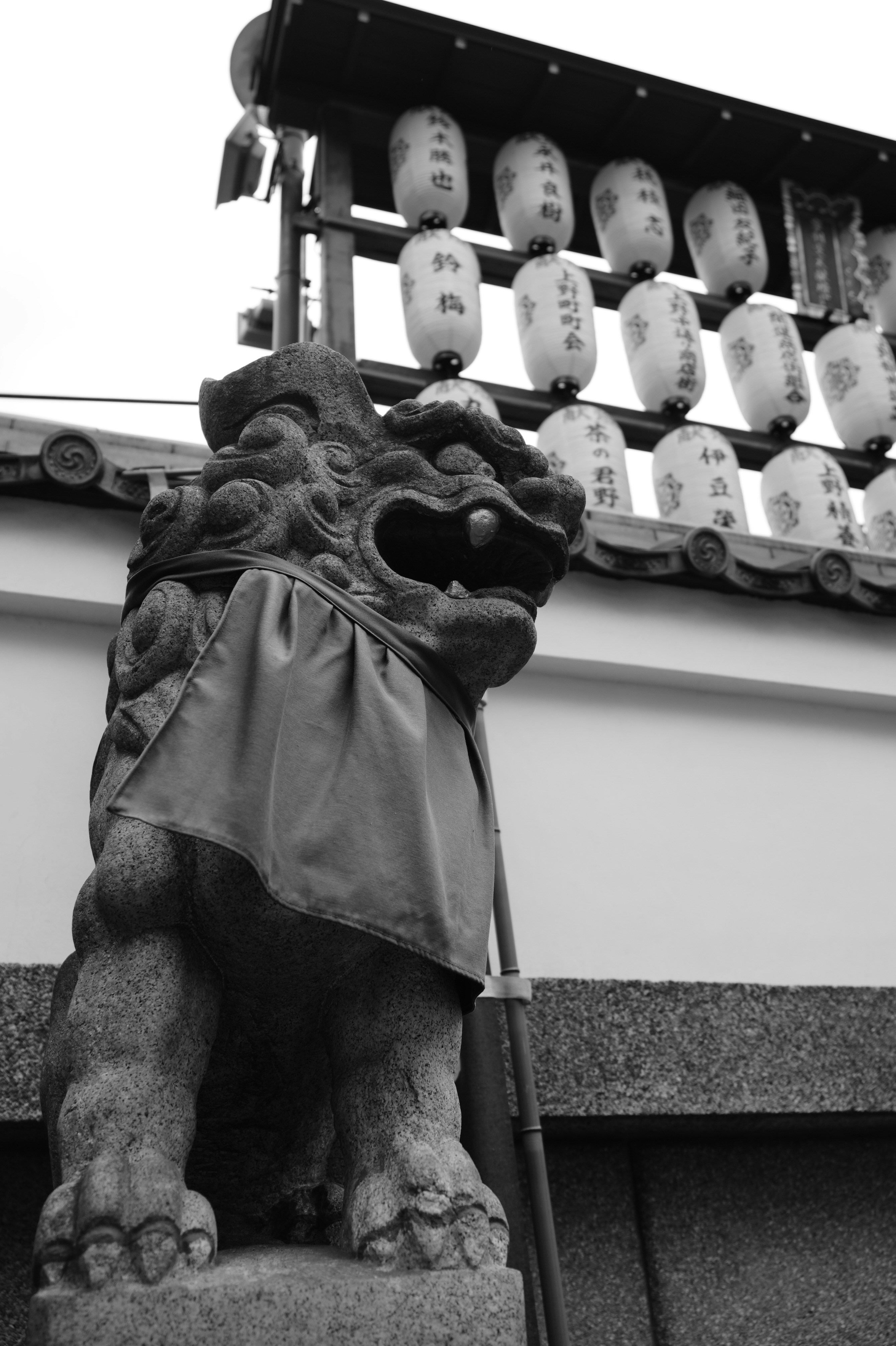 Guardians of the Lantern Gate: A Stone Lion Beneath Lantern Light