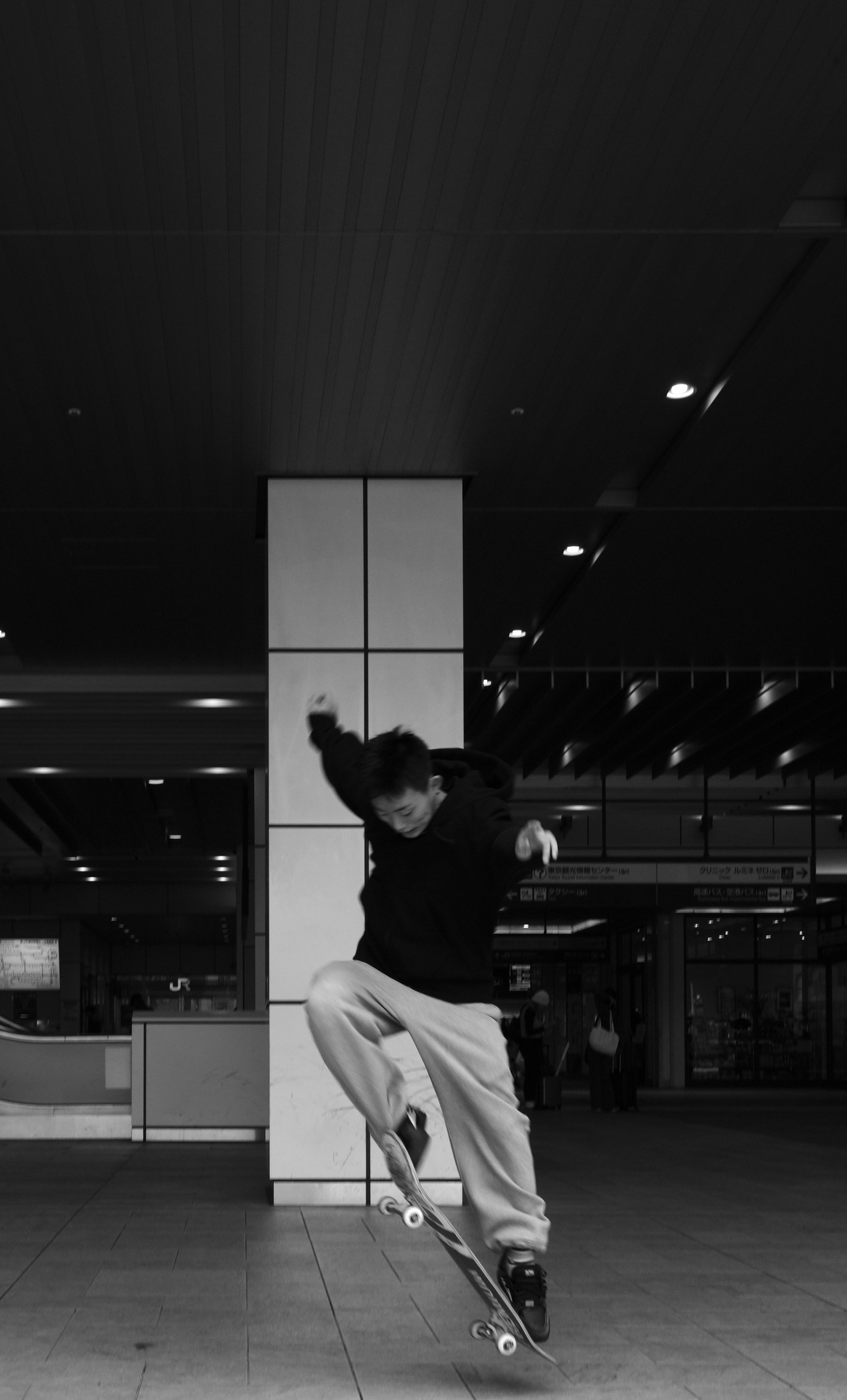 Midair Momentum: Skateboarder Sparks in a Monochrome Station