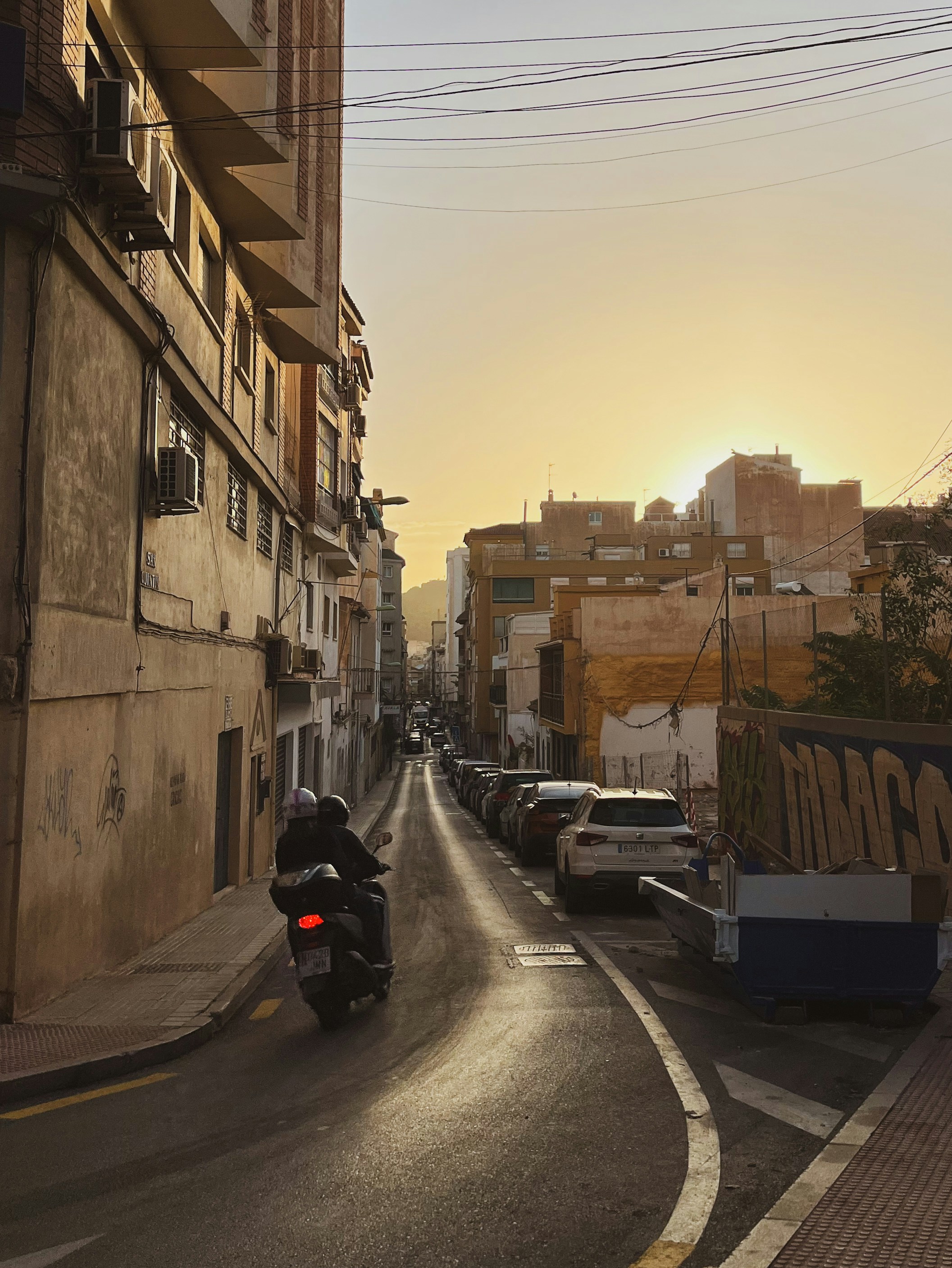 Golden Hour Corridor: Motorcycle, Street, and Sunlit Buildings