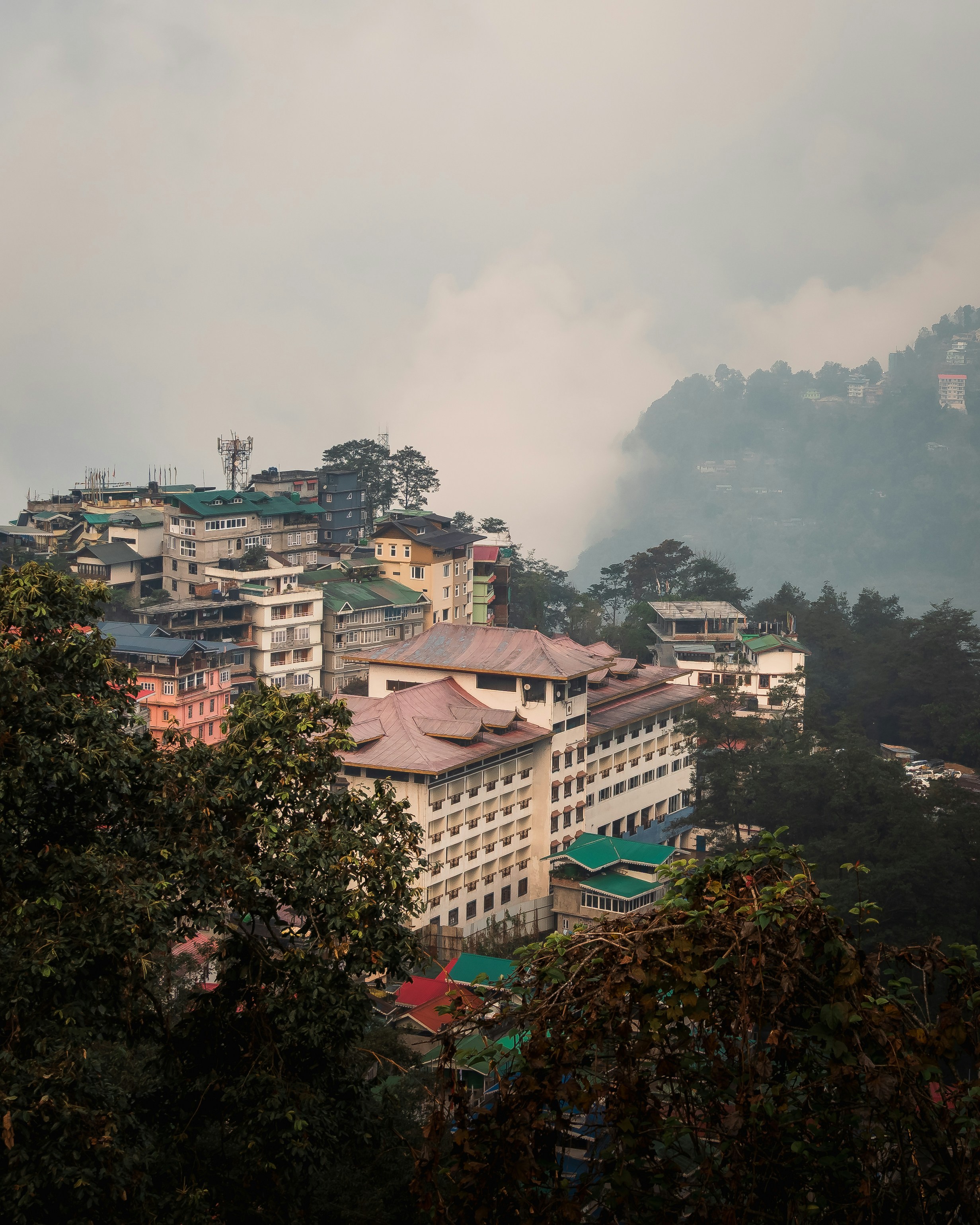 Edificios enclavados en una ladera brumosa de montaña. foto – Imagen de ...