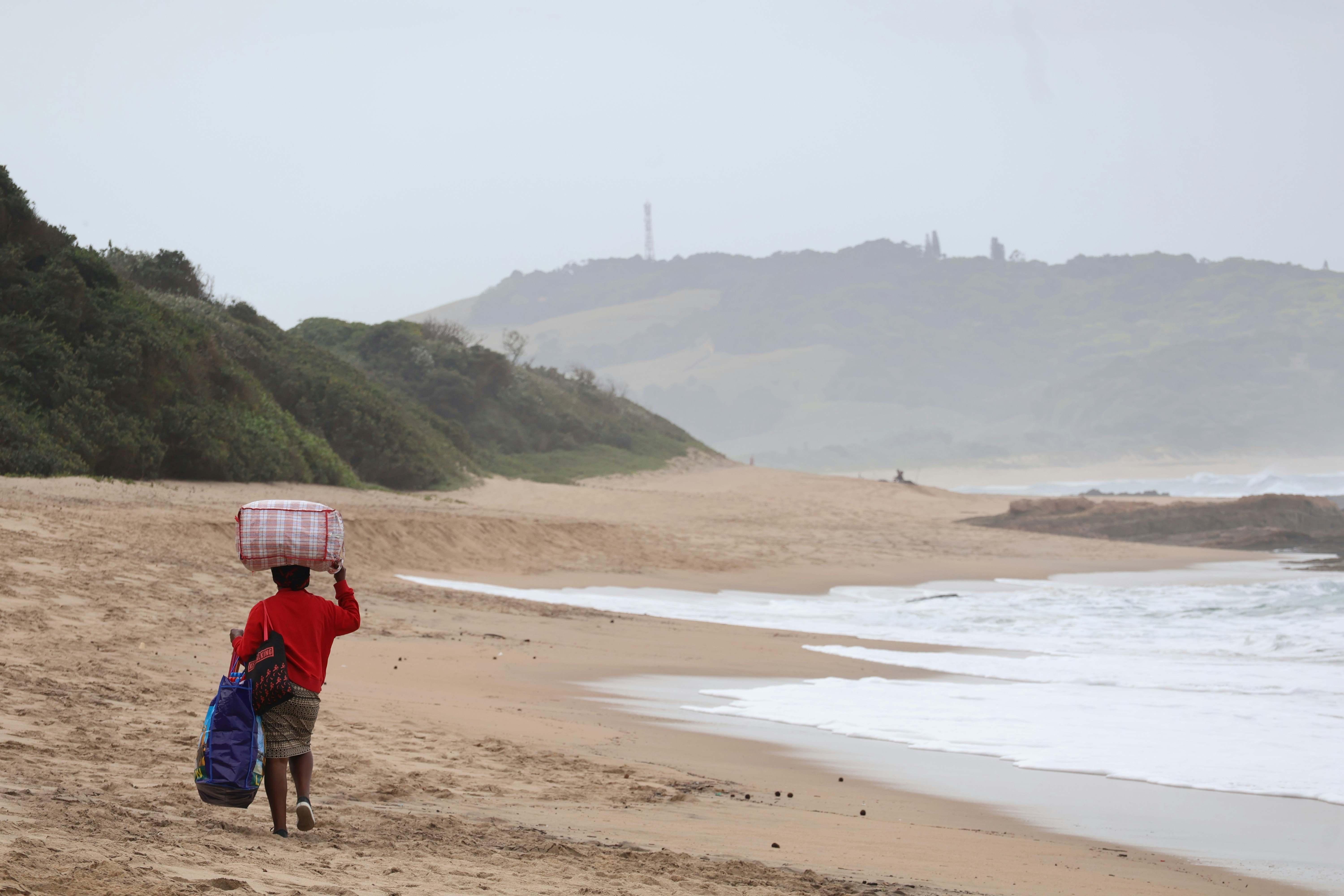 Carrying Home: A lone traveler on a windswept beach