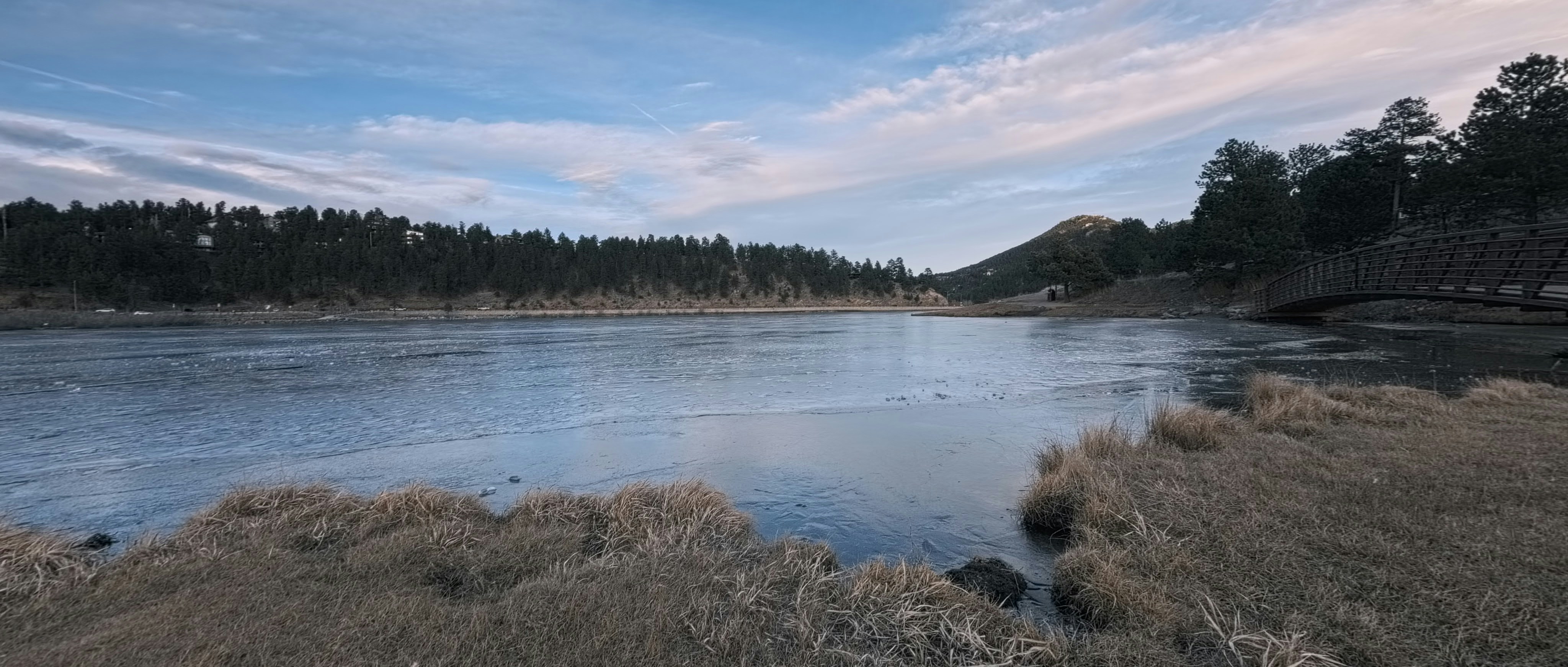 Shoreline Echoes: Calm River Mouth Beneath a Winding Sky